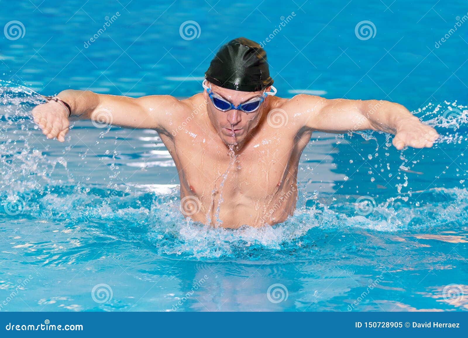 Muscular Swimmer Young Man In Black Cap In Swimming Pool Performing