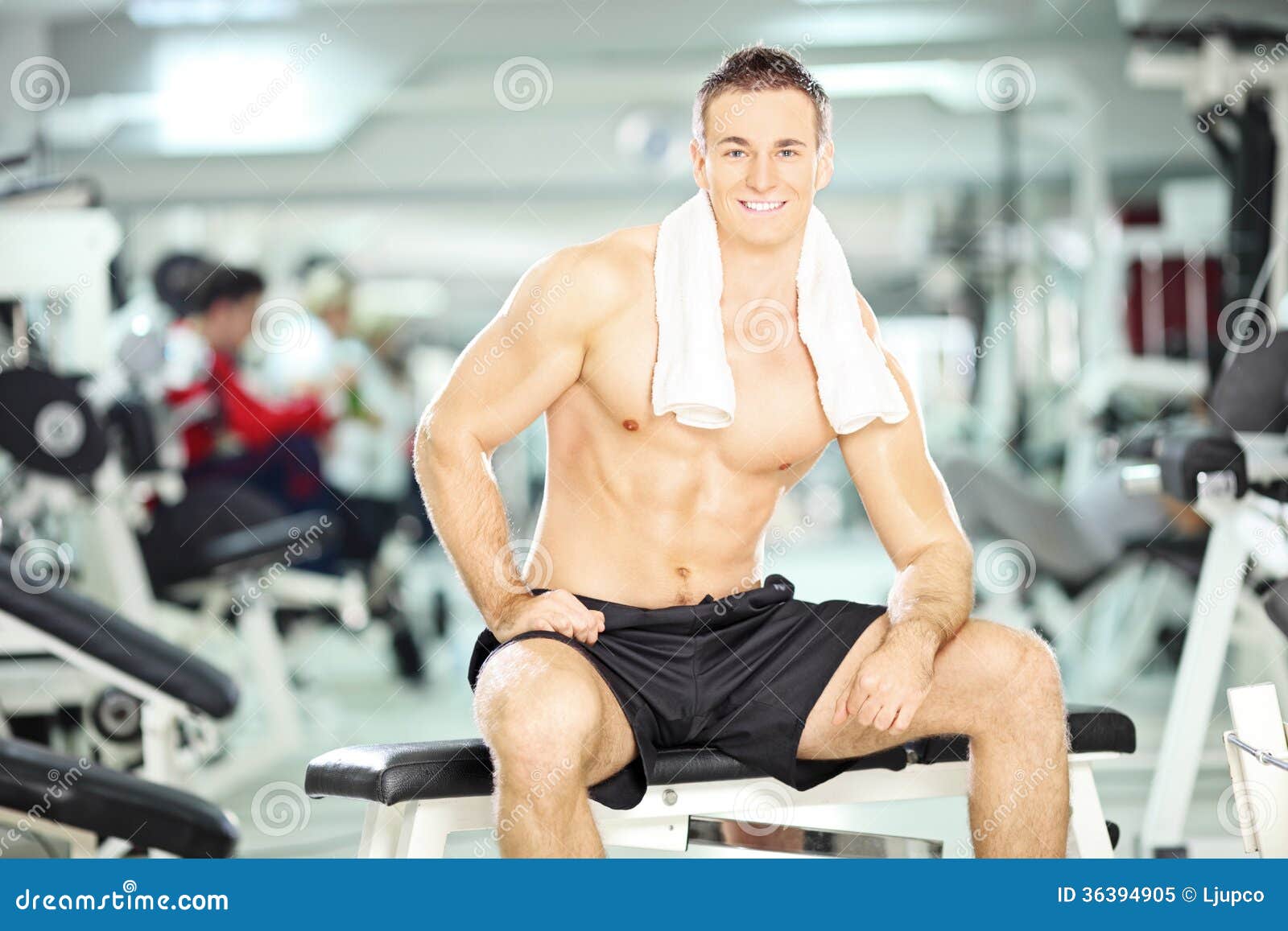 Muscular Young Guy Sitting on a Bench in a Gym Stock Image - Image of ...