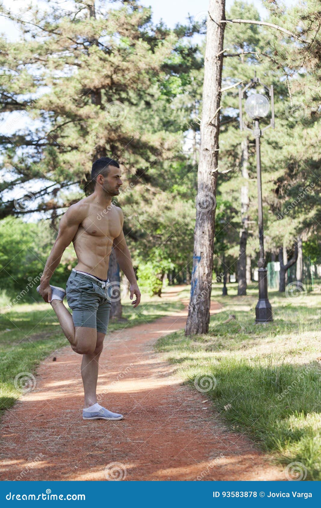 Muscular Young Man Doing Stretching Exercises in the Park Stock Photo ...