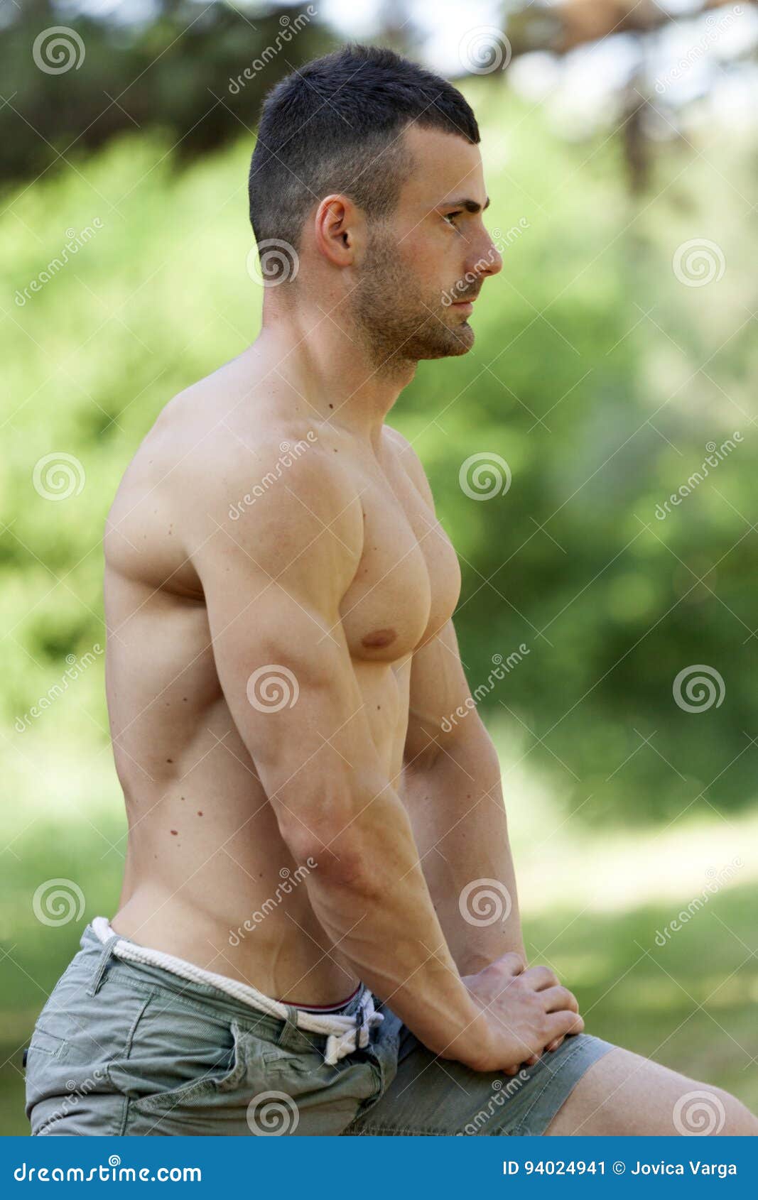Muscular Young Man Doing Stretching Exercises in the Park Stock Image ...