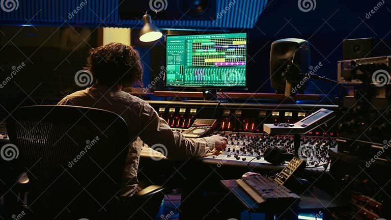 Music Producer Editing Tracks with Mixing Console and Audio Software in ...