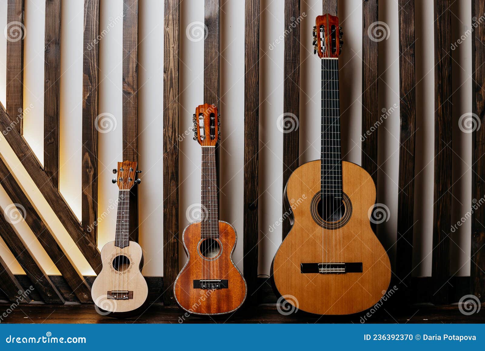 Musical Instruments: Three Guitars of Different Sizes on a Wooden ...
