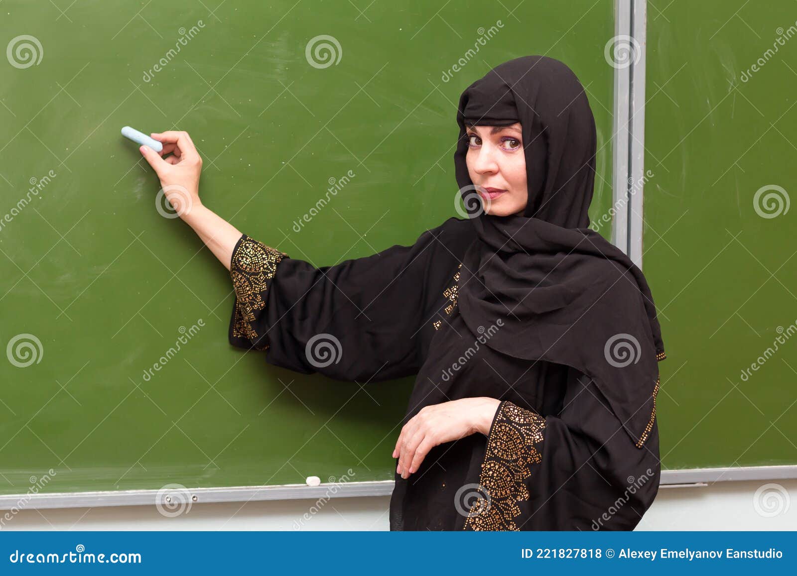 A Muslim Teacher Writes with Chalk on Blackboard Stock Photo - Image of ...