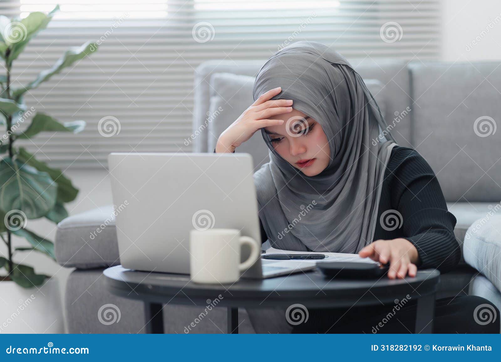 A Muslim Woman Appears Stressed and Concerned while Looking at Her ...