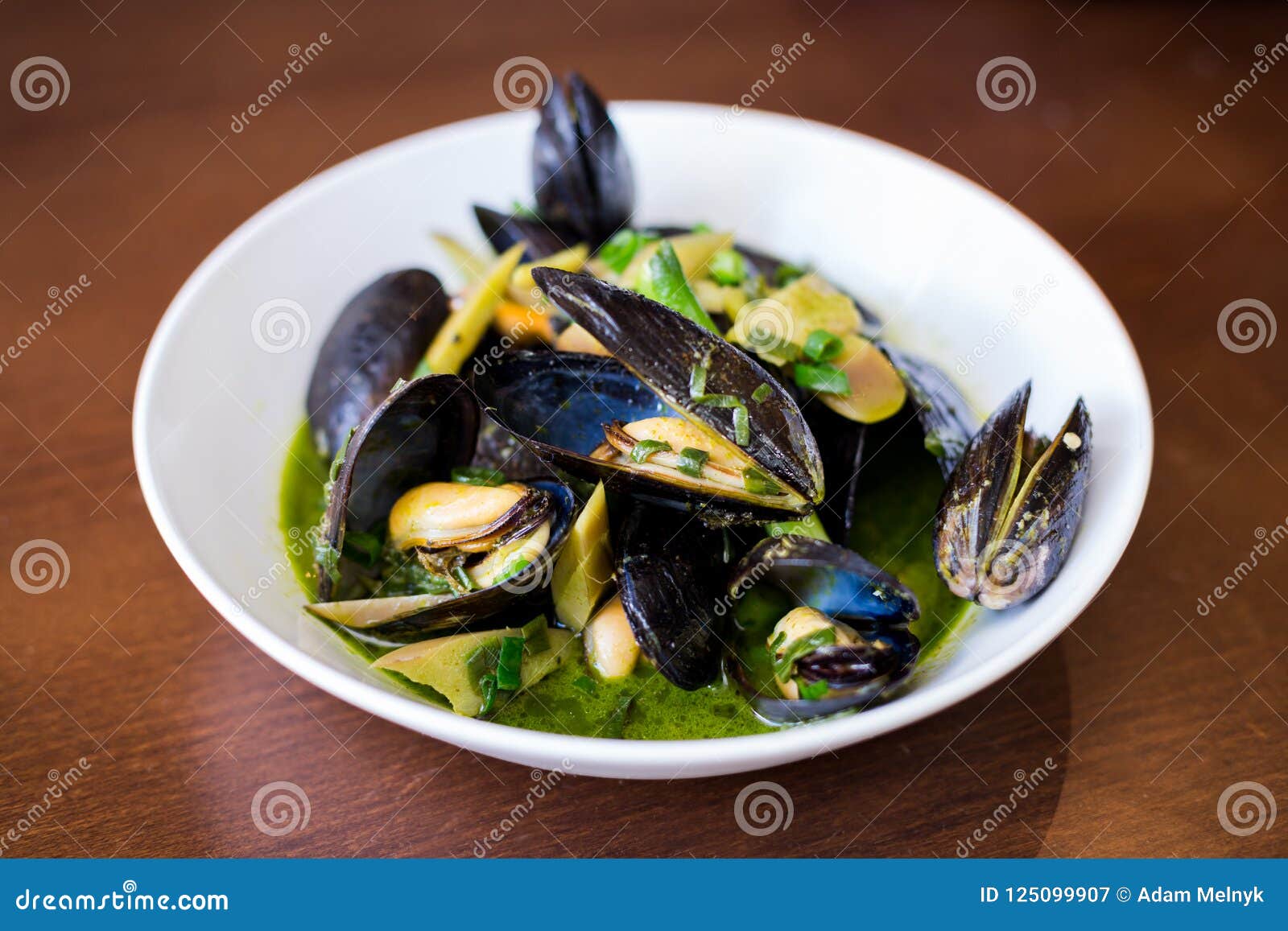 Mussels in Shells in a White Bowl with a Green Sauce on a Dining Table ...