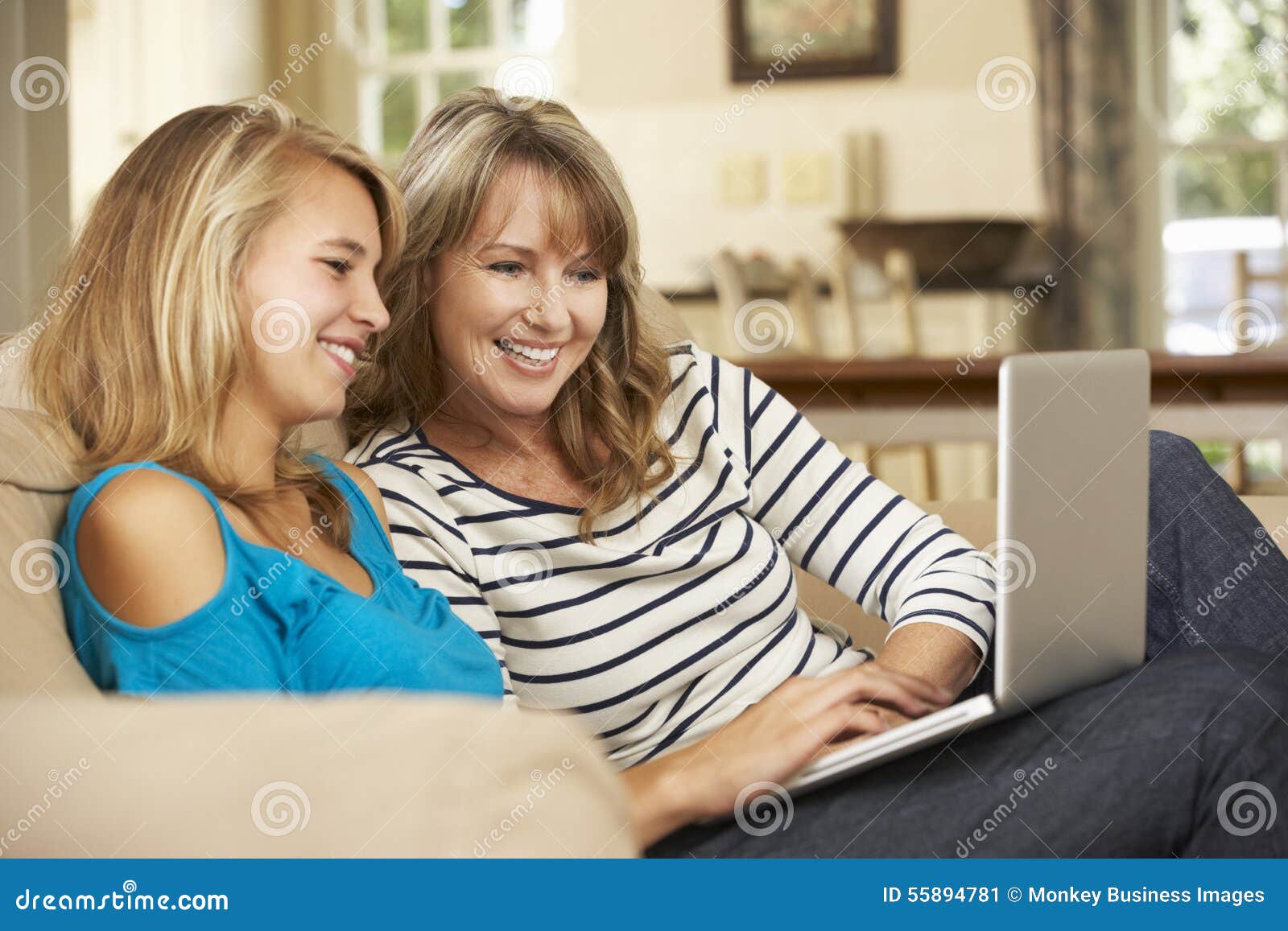 Mutter Mit Der Jugendlichen Tochter, Die Auf Sofa at Home Using Laptop ...