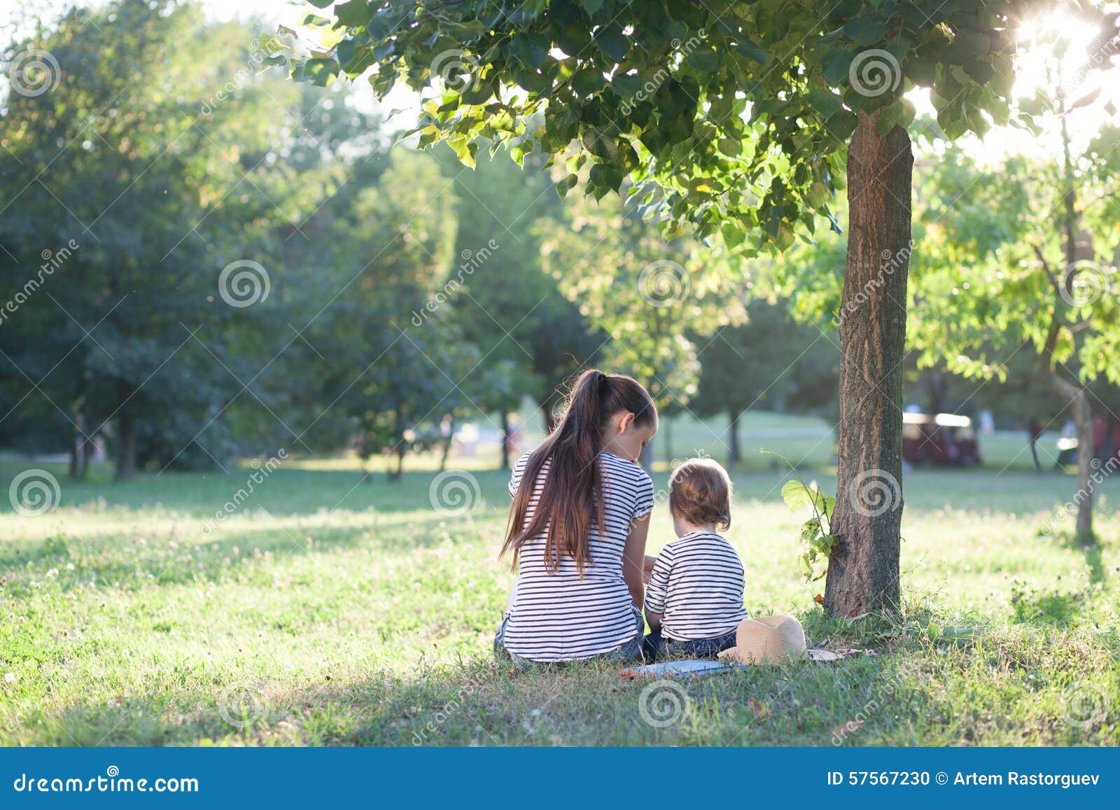 Mutter Und Kleinkind, Die Unter Dem Baum Sitzen Stockfoto - Bild von ...