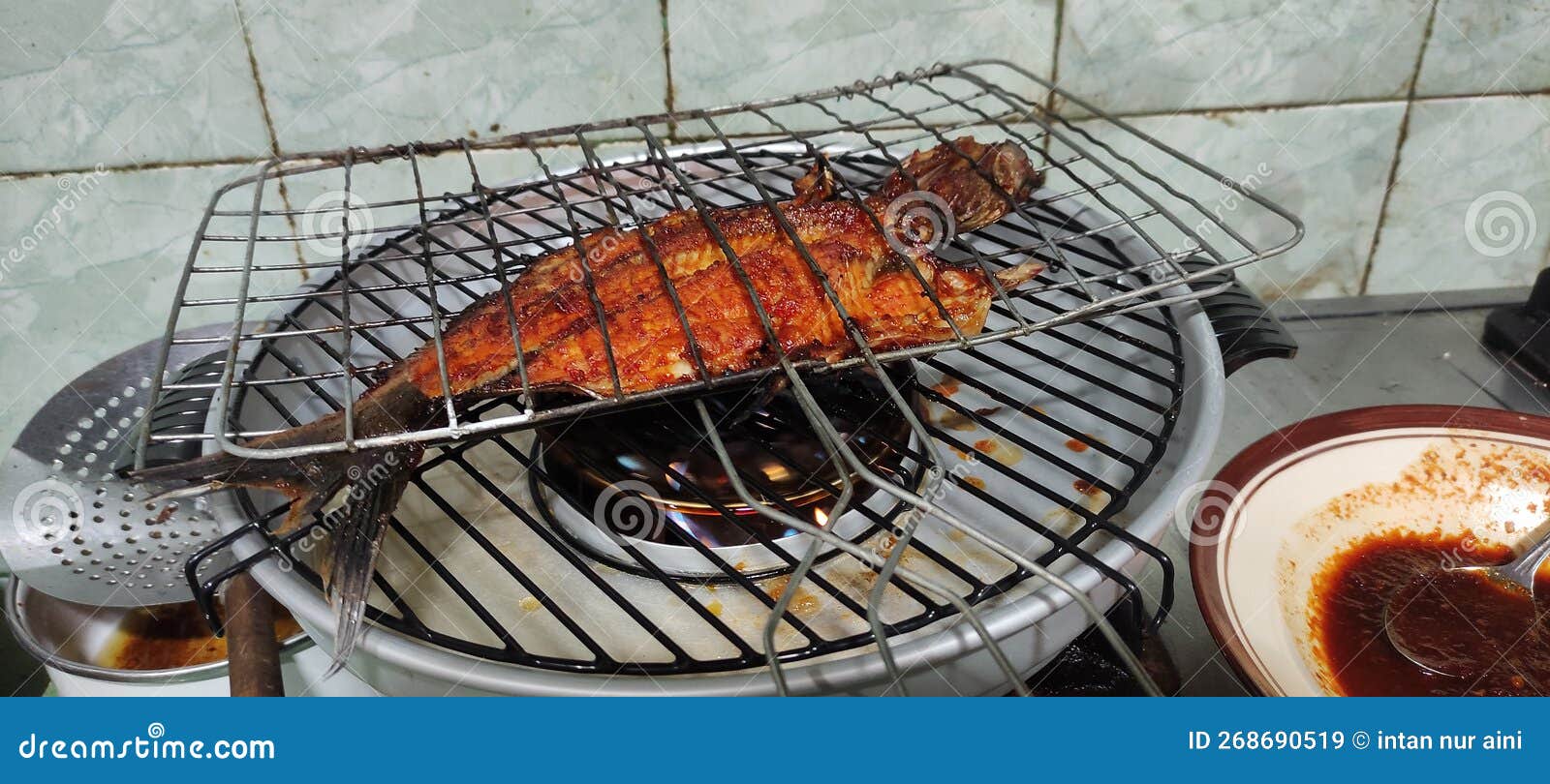 My Mom Cooking Patin Fish Using New Grill Stock Image - Image of patin ...