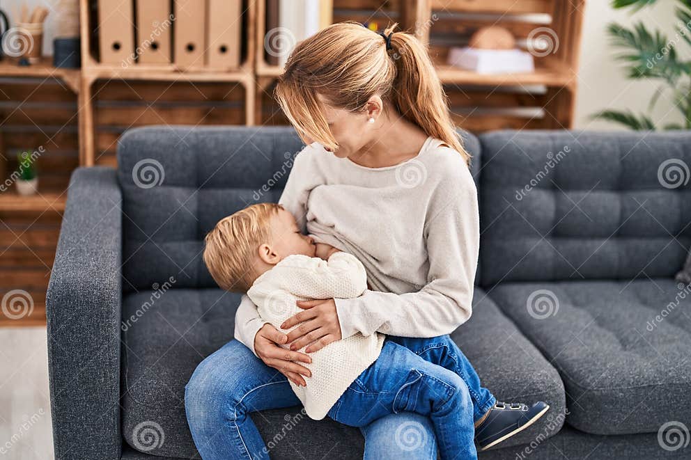 Mère Et Fils Enfant Allaitant Assis Sur Le Canapé à La Maison Image