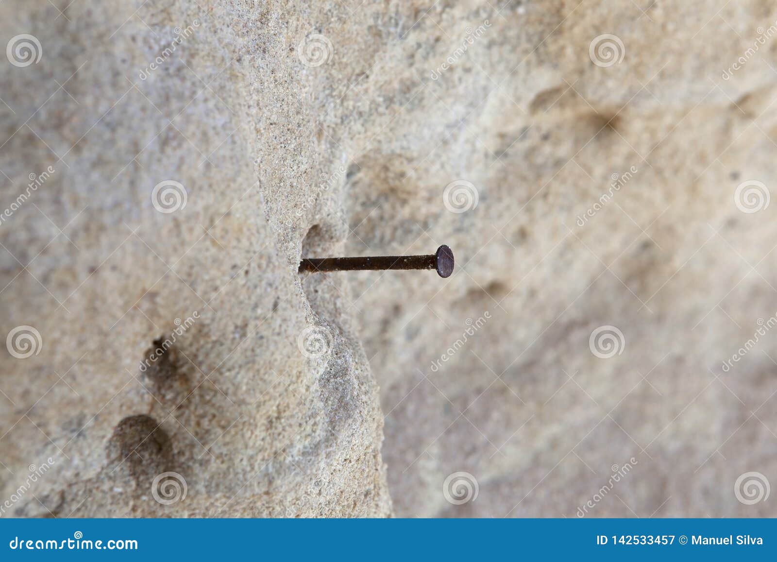 Nail on the wall and sand stock image. Image of design - 142533457