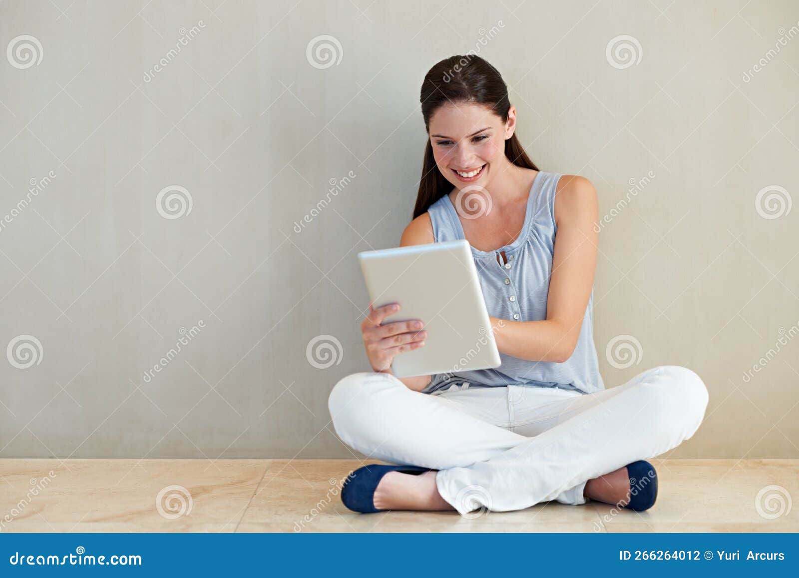 Navigating Her Tablet with Ease. a Pretty Young Woman Sitting on the ...