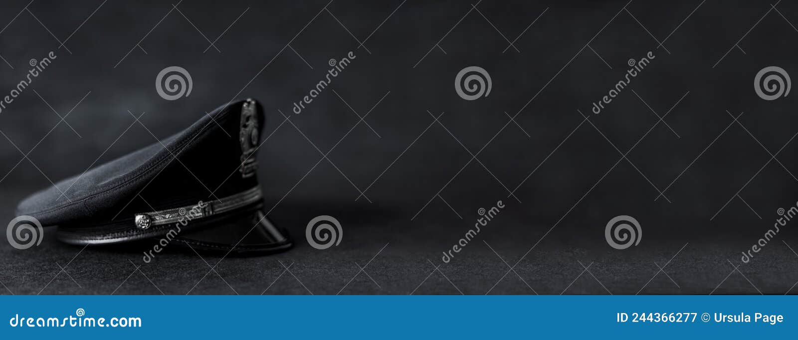 A Navy Blue Police Hat Cap in Front of a Navy Blue Background with Copy ...