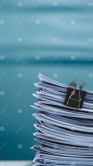 Neat Stack of Papers with Black Clip on Blue Background, Exuding ...