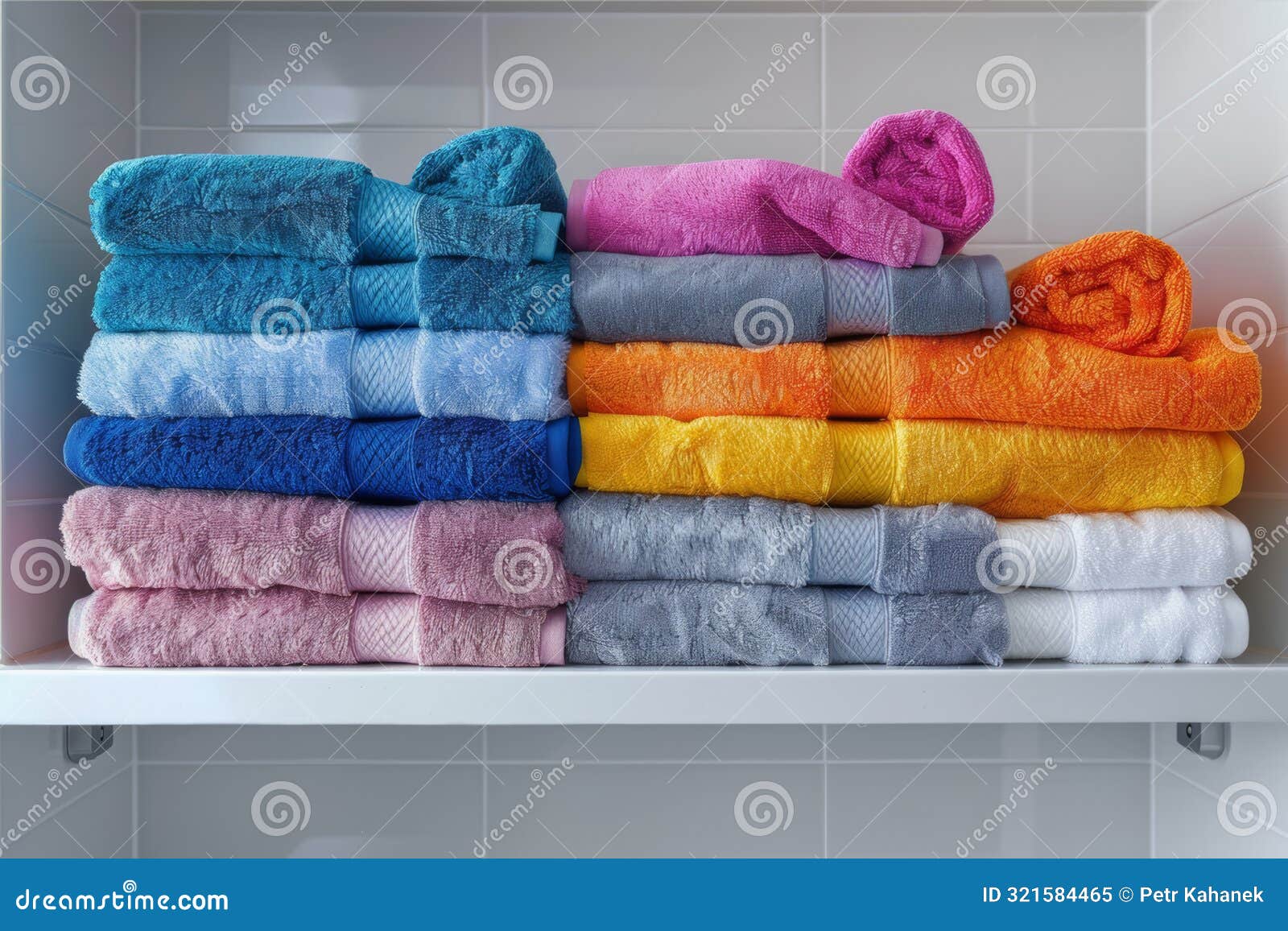 A Neatly Folded Stack of Colorful Towels on a White Shelf in a Modern ...