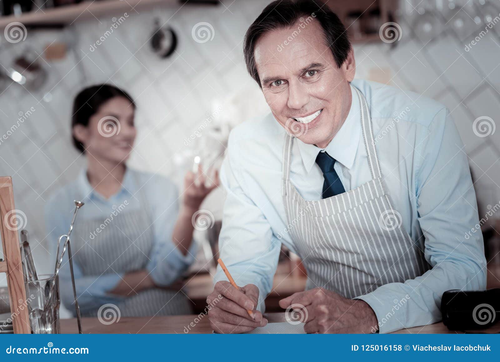 Smiling Waiter Making Notes and Feeling Glad Stock Photo - Image of ...