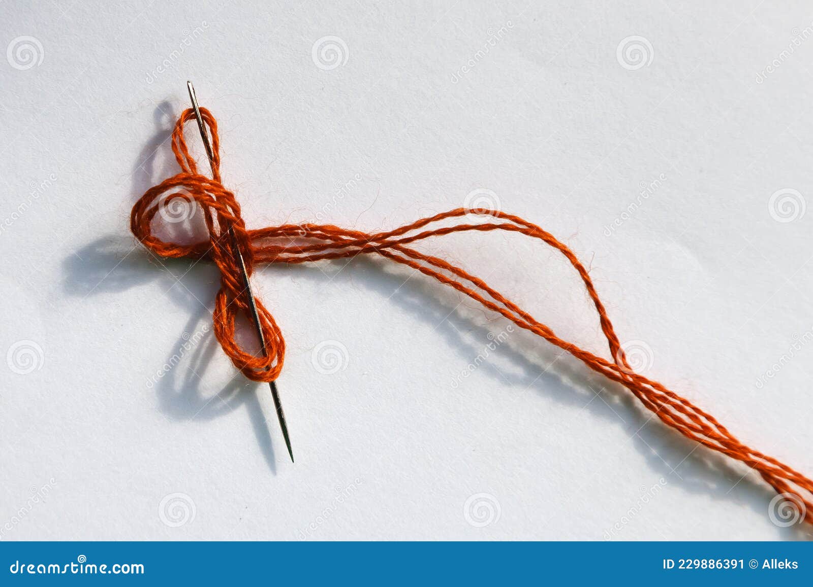 Needle and Orange Thread on White Paper Surface Stock Image - Image of ...