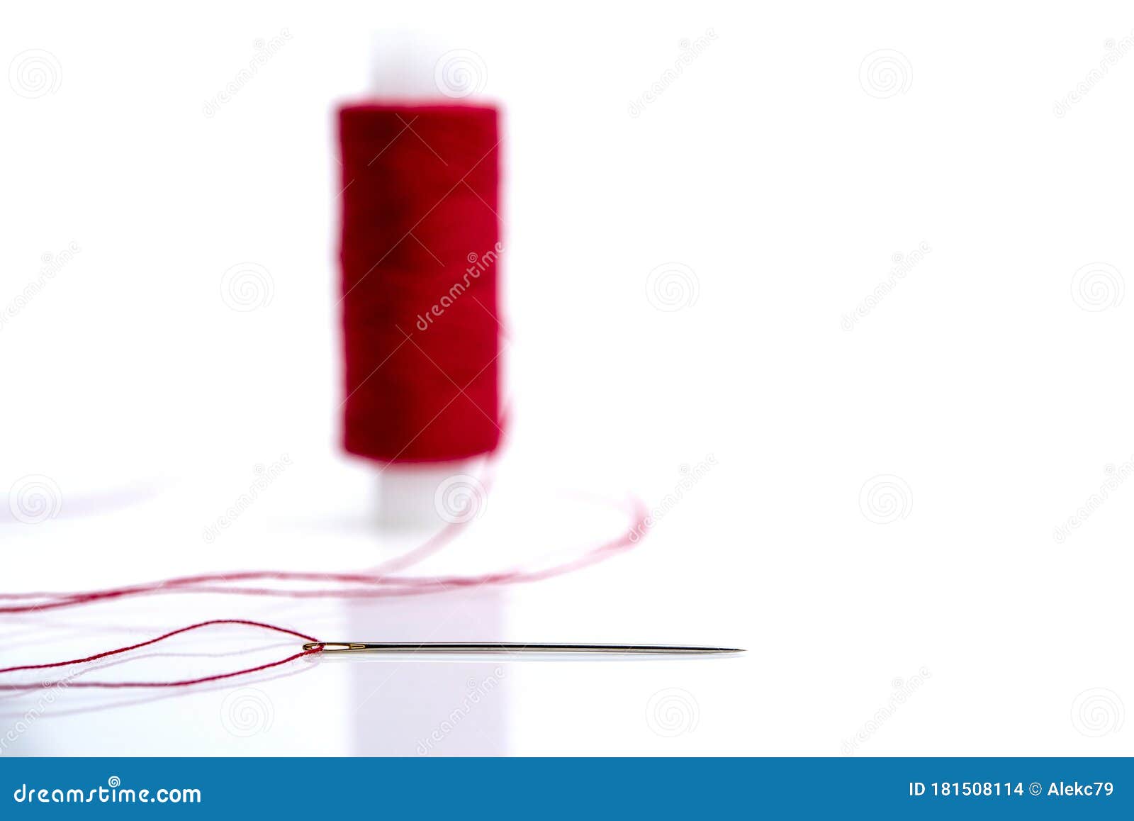 Needle with Red Thread on the Background of a Spool of Thread Stock ...