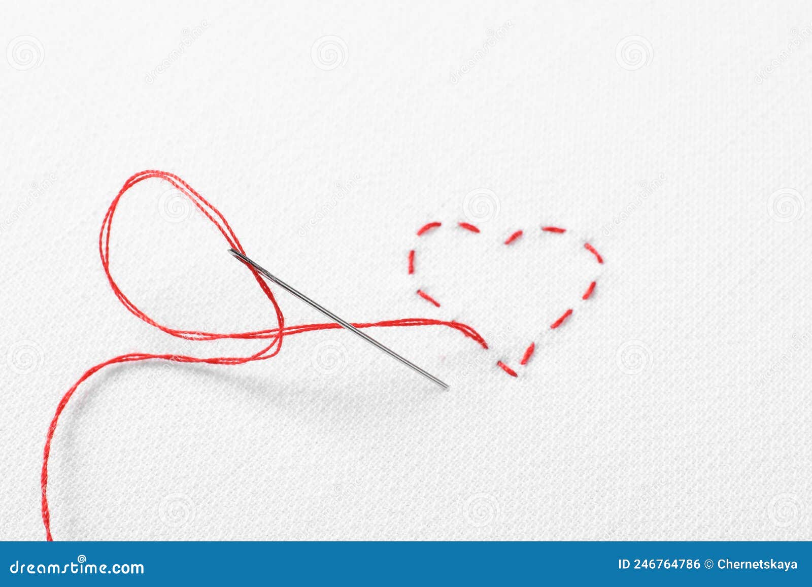 Needle with Red Thread and Stitches in Shape of Heart on White Fabric ...