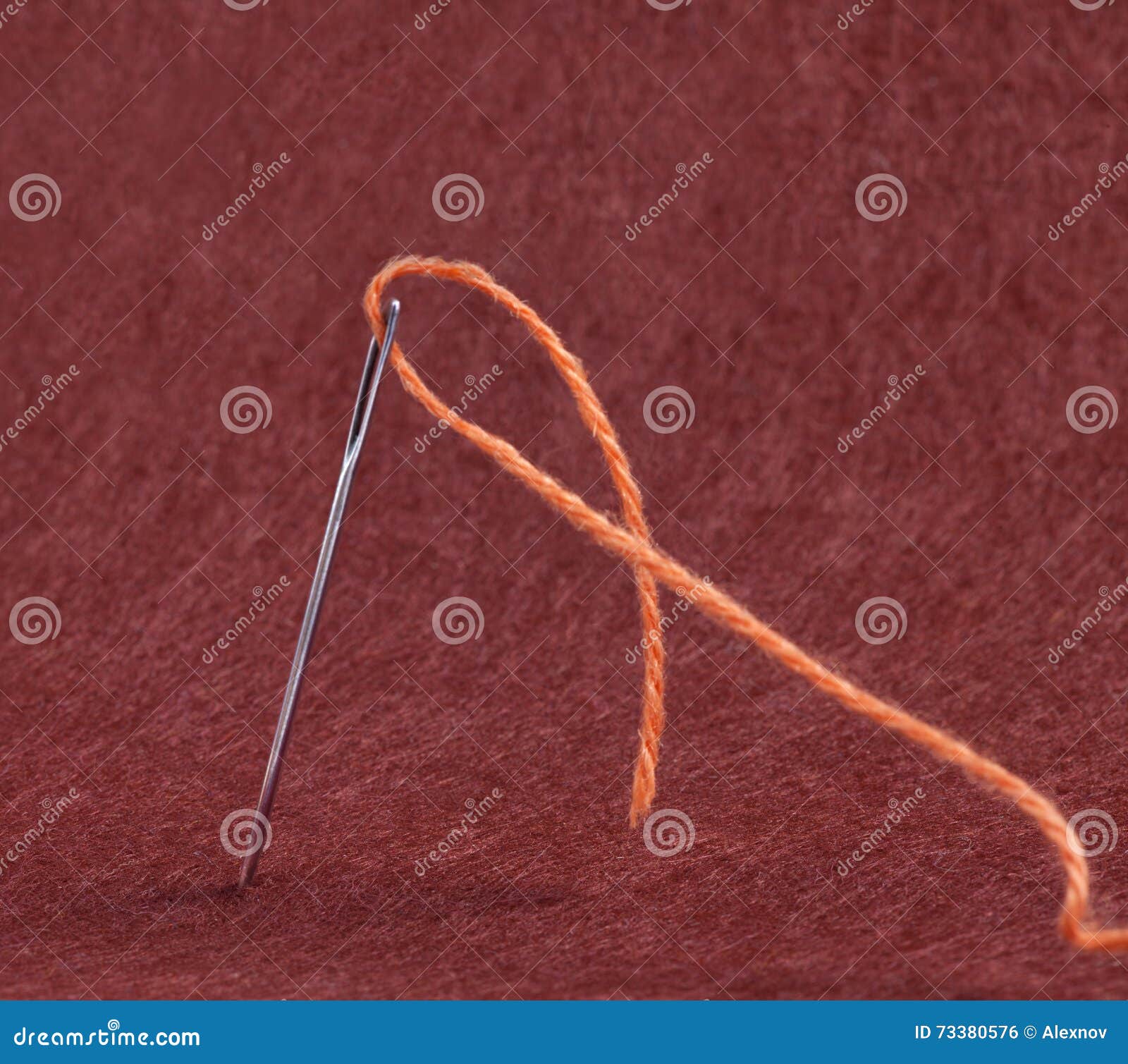 Needle and Thread of Yarn on the Red Felt Fabric Background Tex Stock ...
