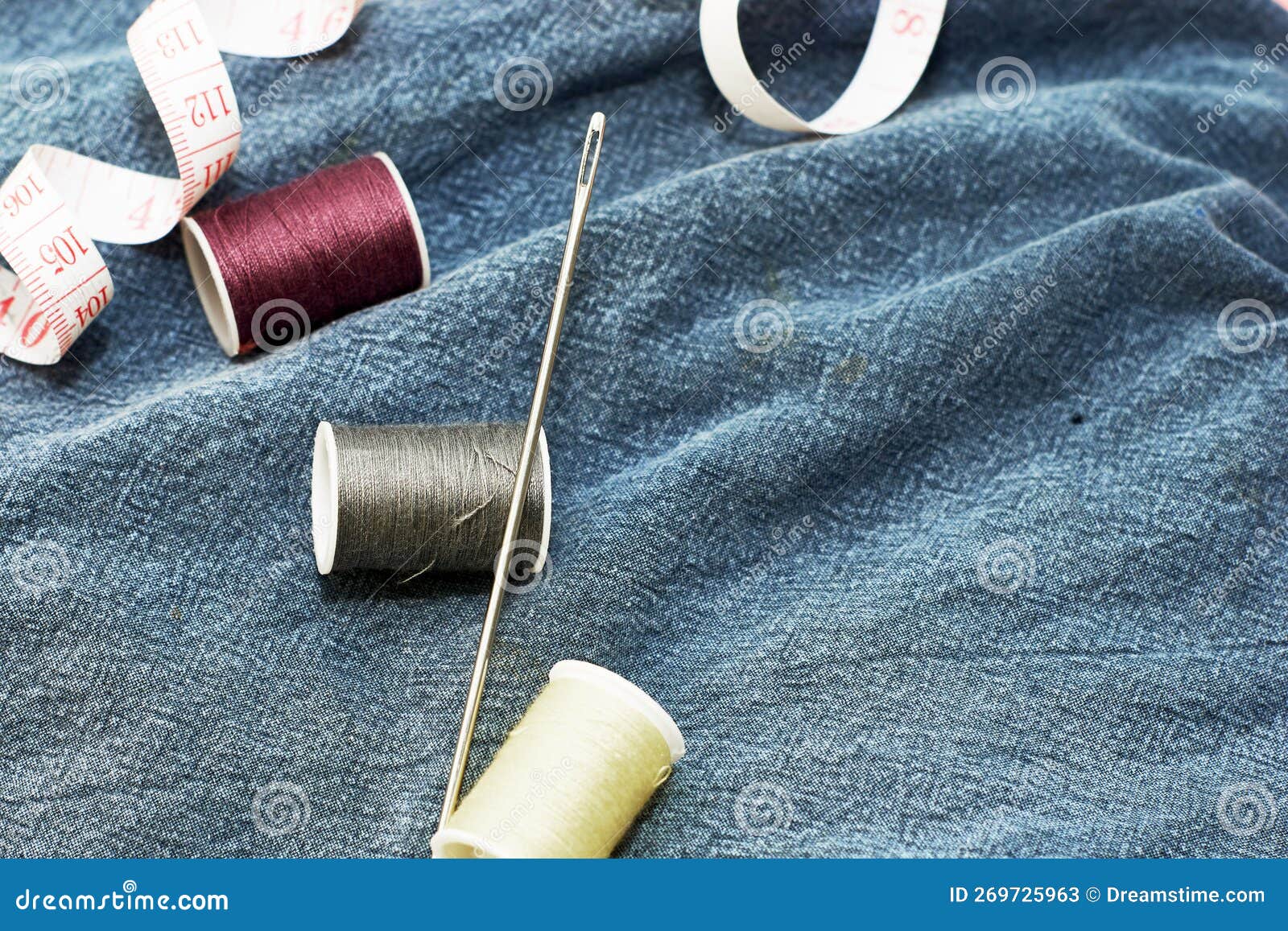 Needles Measuring Tape and Thread on the Background of Torn Jeans the ...