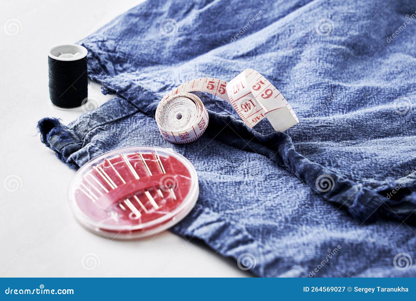 Needles Measuring Tape and Thread on the Background of Torn Jeans the ...