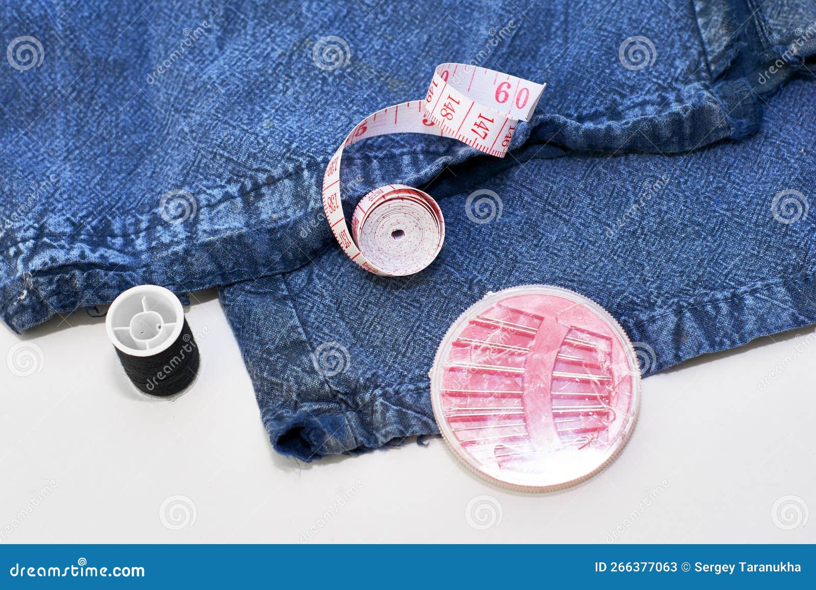 Needles Measuring Tape and Thread on the Background of Torn Jeans the ...