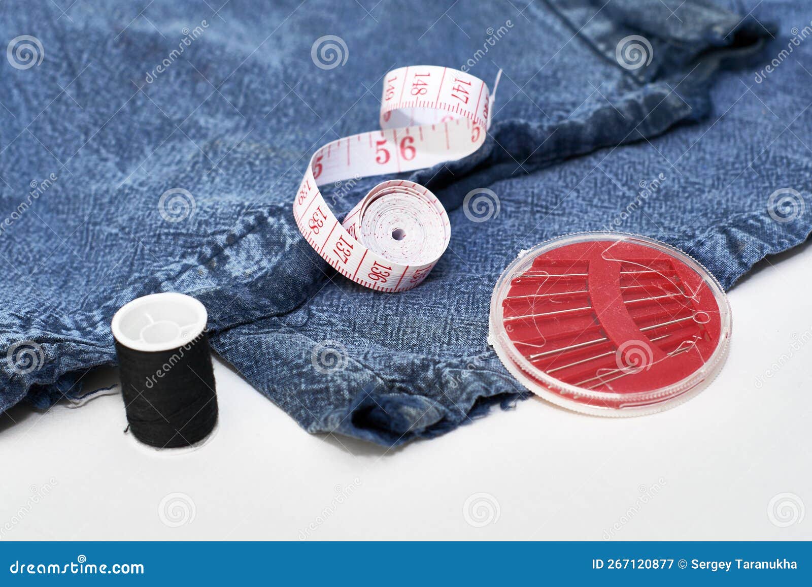 Needles Measuring Tape and Thread on the Background of Torn Jeans the ...
