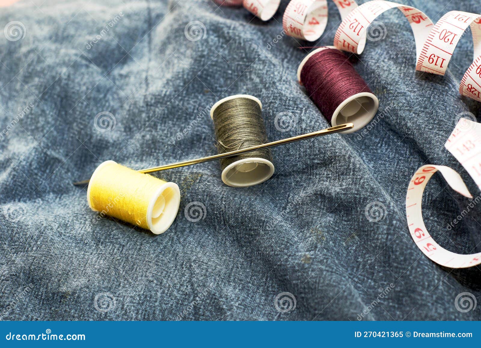 Needles Measuring Tape and Thread on the Background of Torn Jeans the ...