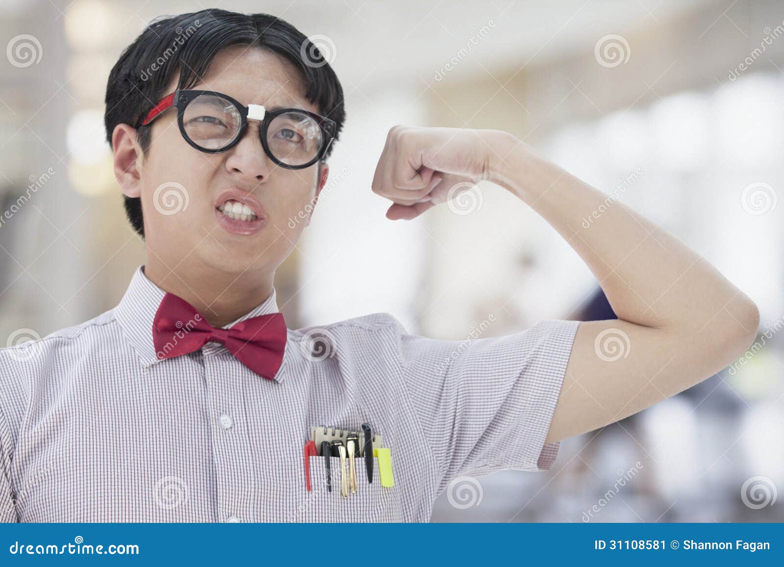 Nerdy Man with Glasses Making a Face and Flexing His Bicep Stock Image ...