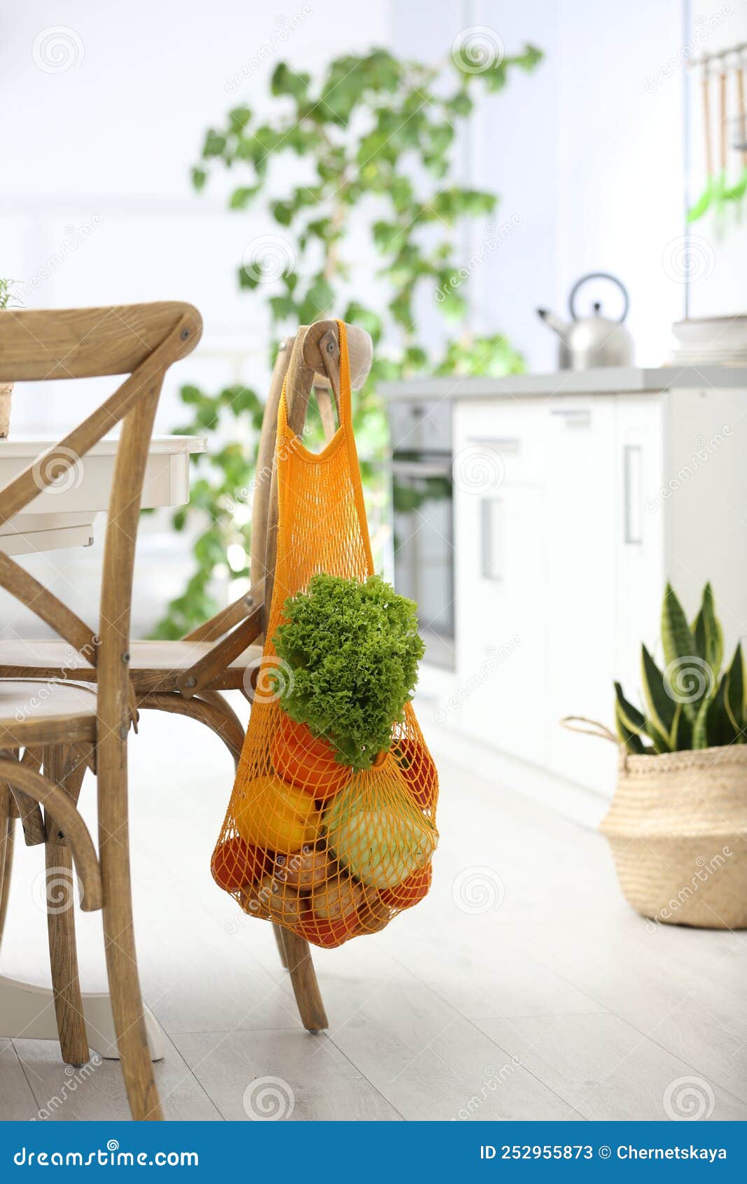 Net Bag with Vegetables Hanging on Wooden Chair in Kitchen Stock Image ...