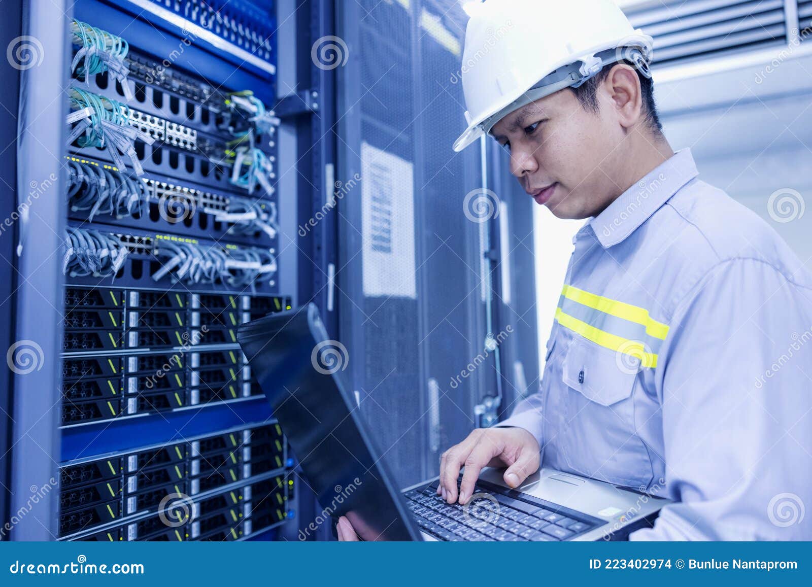 Network Administrator Holding Laptop in Hand Working Configuration with ...