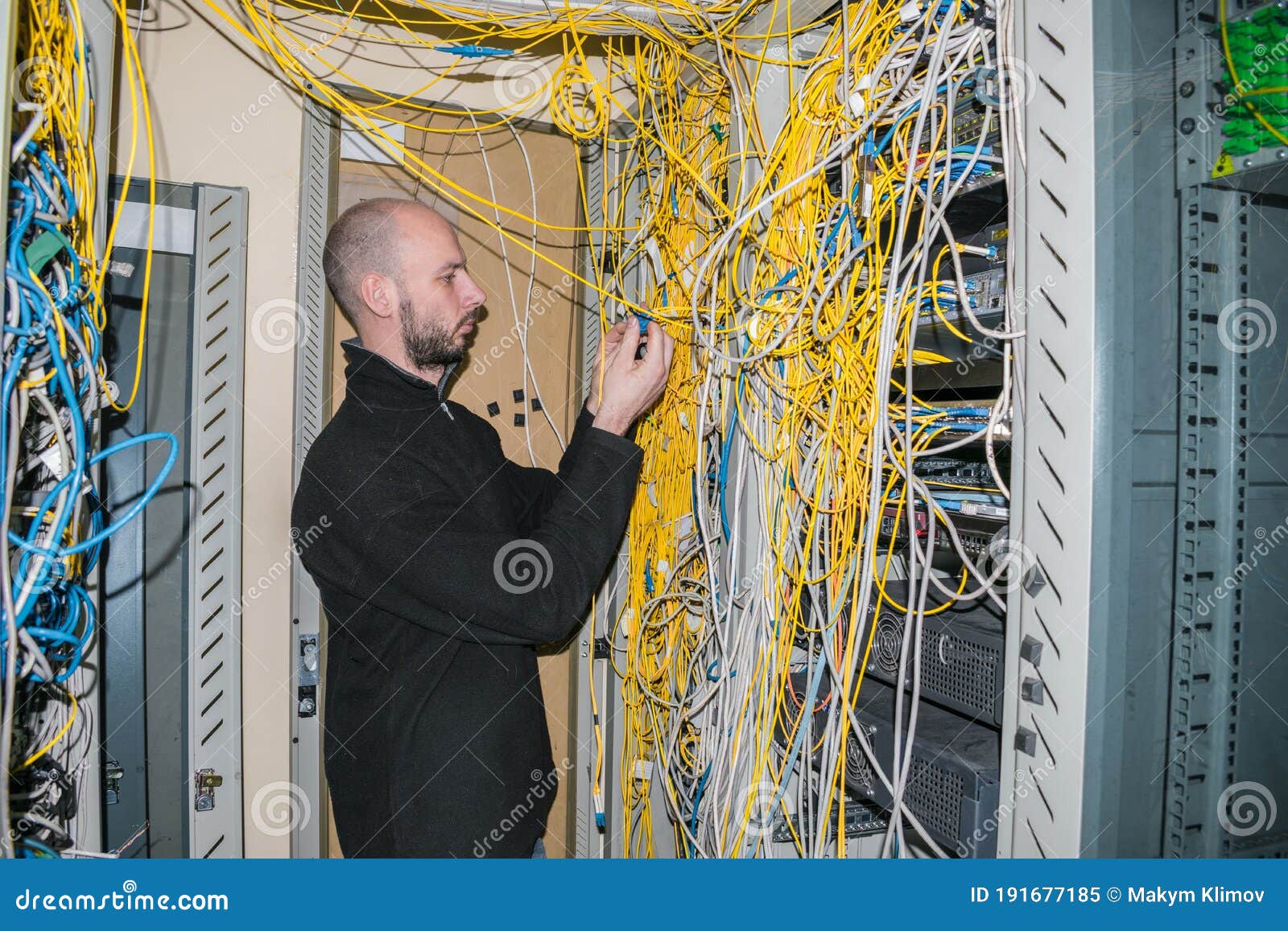 A Network Engineer Connects Two Patch Cord in the Server Room of the ...