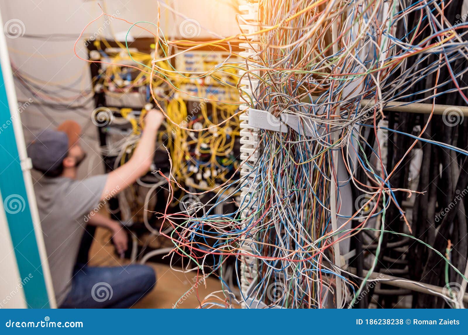 Network Engineer Working in Server Room. Connecting Network Cables To ...