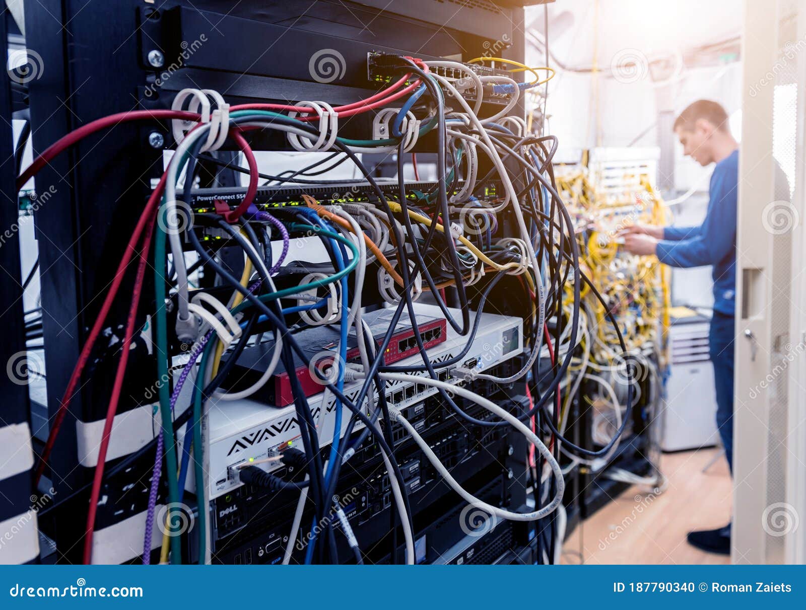 Network Engineer Working in Server Room. Connecting Network Cables To ...