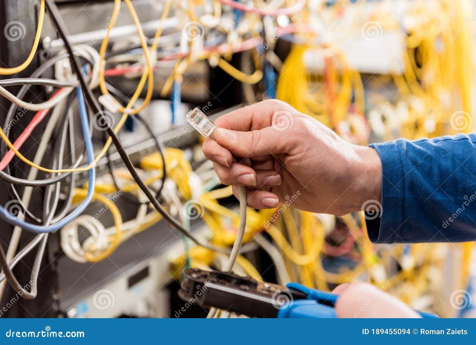 Network Engineer Working in Server Room. Connecting Network Cables To ...