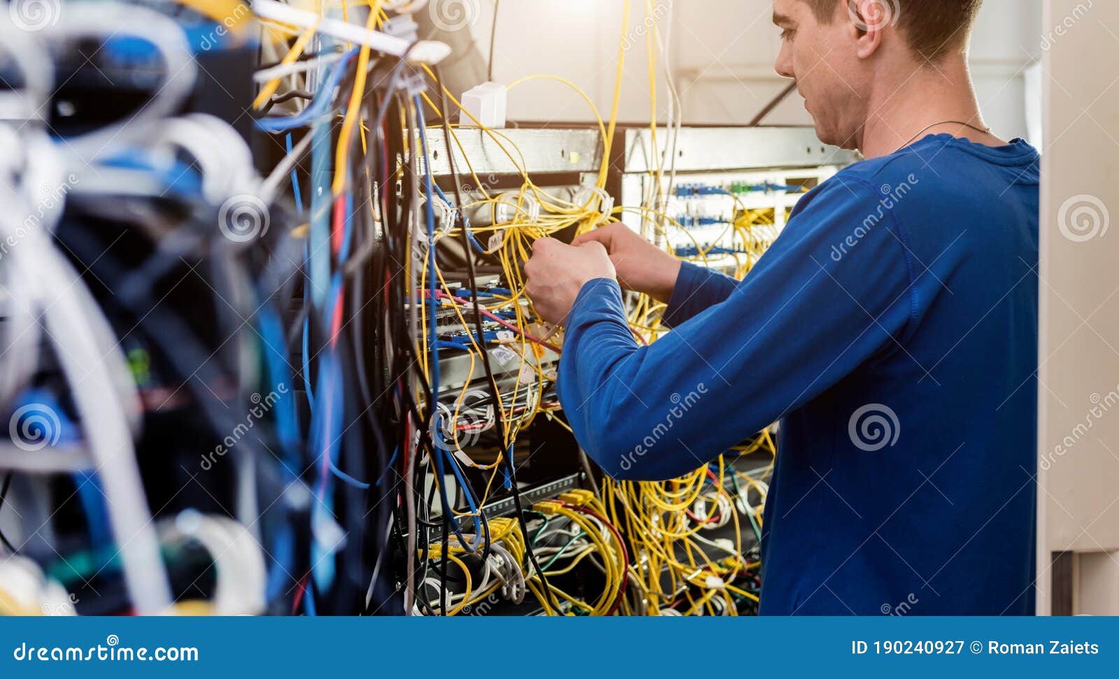 Network Engineer Working in Server Room. Connecting Network Cables To ...