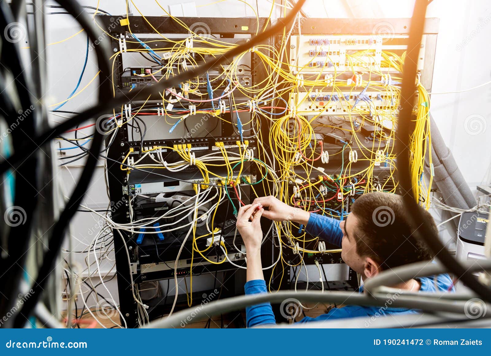 Network Engineer Working in Server Room. Connecting Network Cables To ...