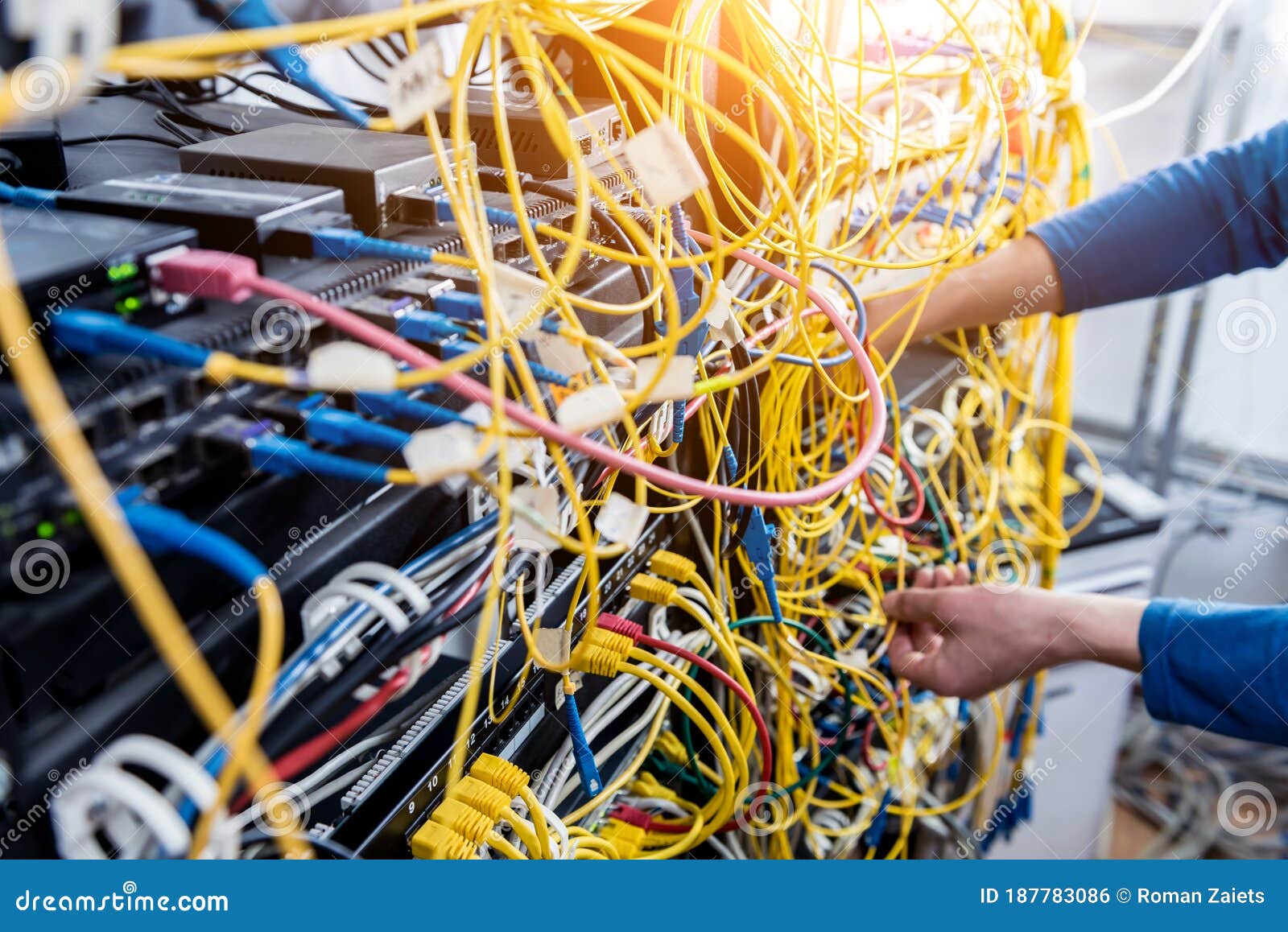Network Engineer Working in Server Room. Connecting Network Cables To ...