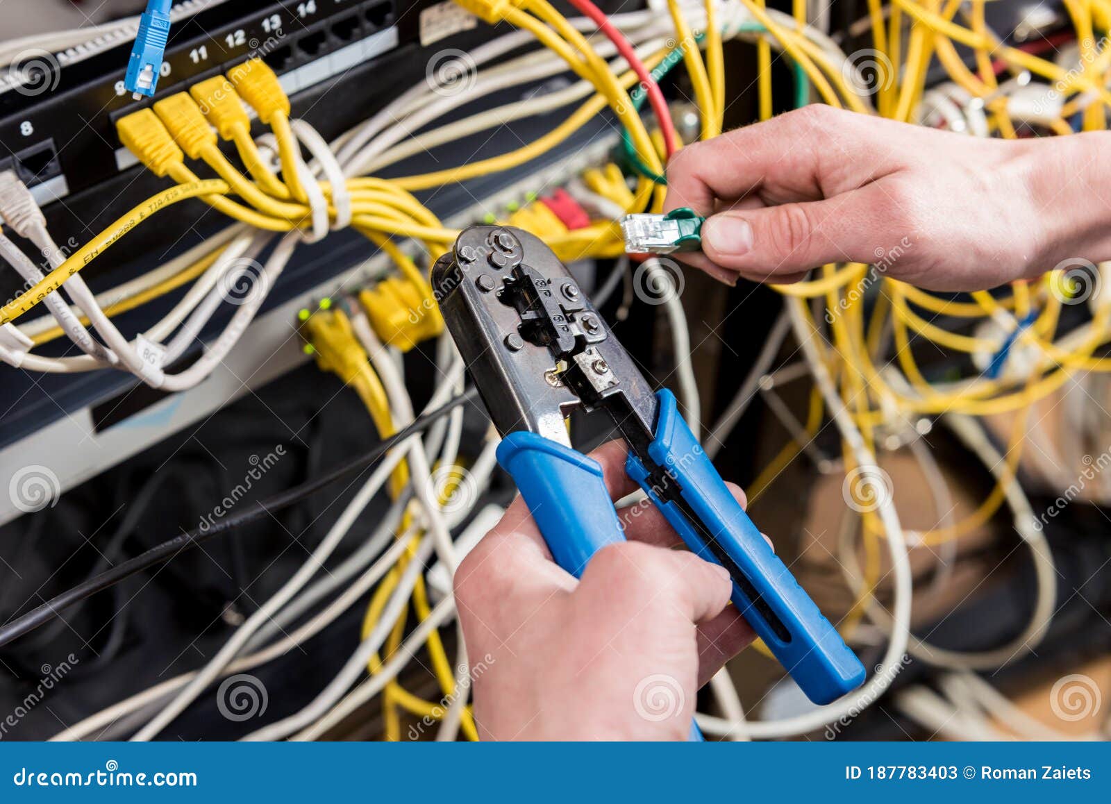 Network Engineer Working in Server Room. Connecting Network Cables To ...