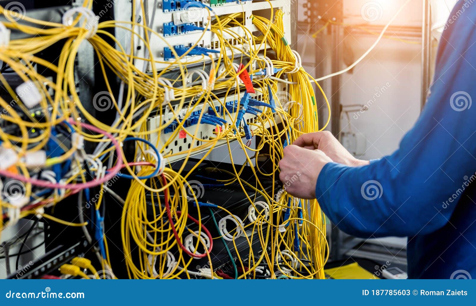 Network Engineer Working in Server Room. Connecting Network Cables To ...