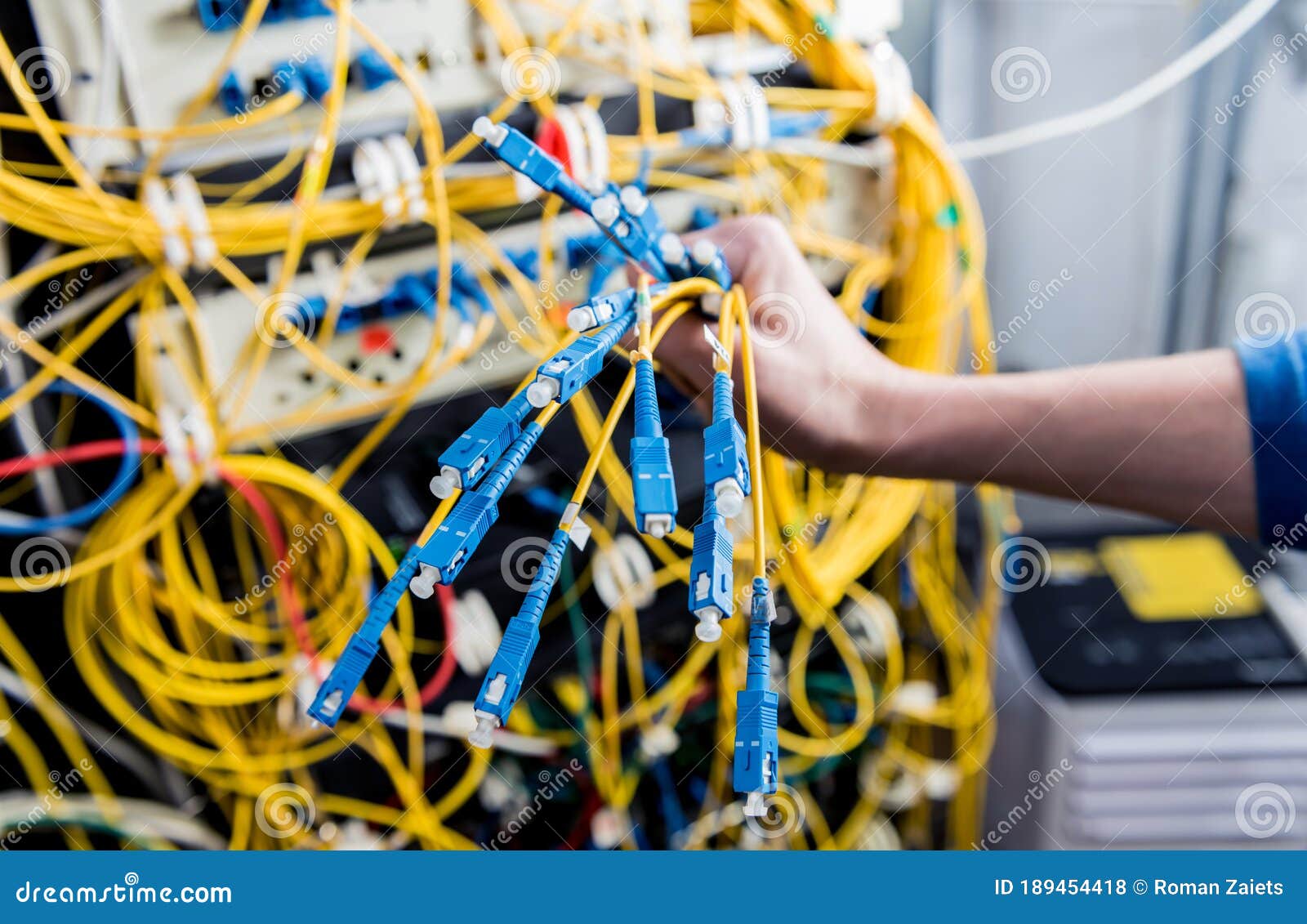 Network Engineer Working in Server Room. Connecting Network Cables To ...