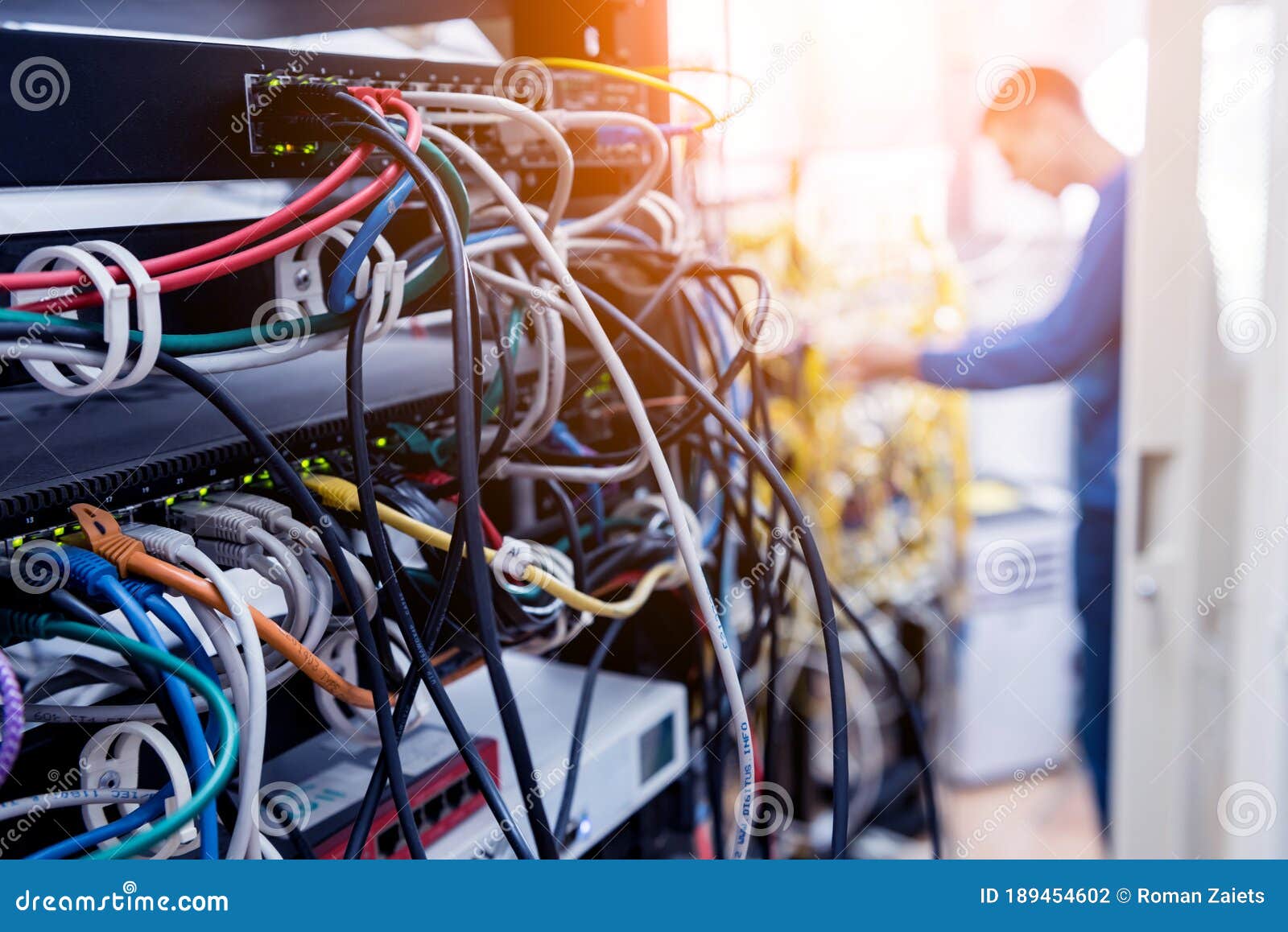 Network Engineer Working in Server Room. Connecting Network Cables To ...