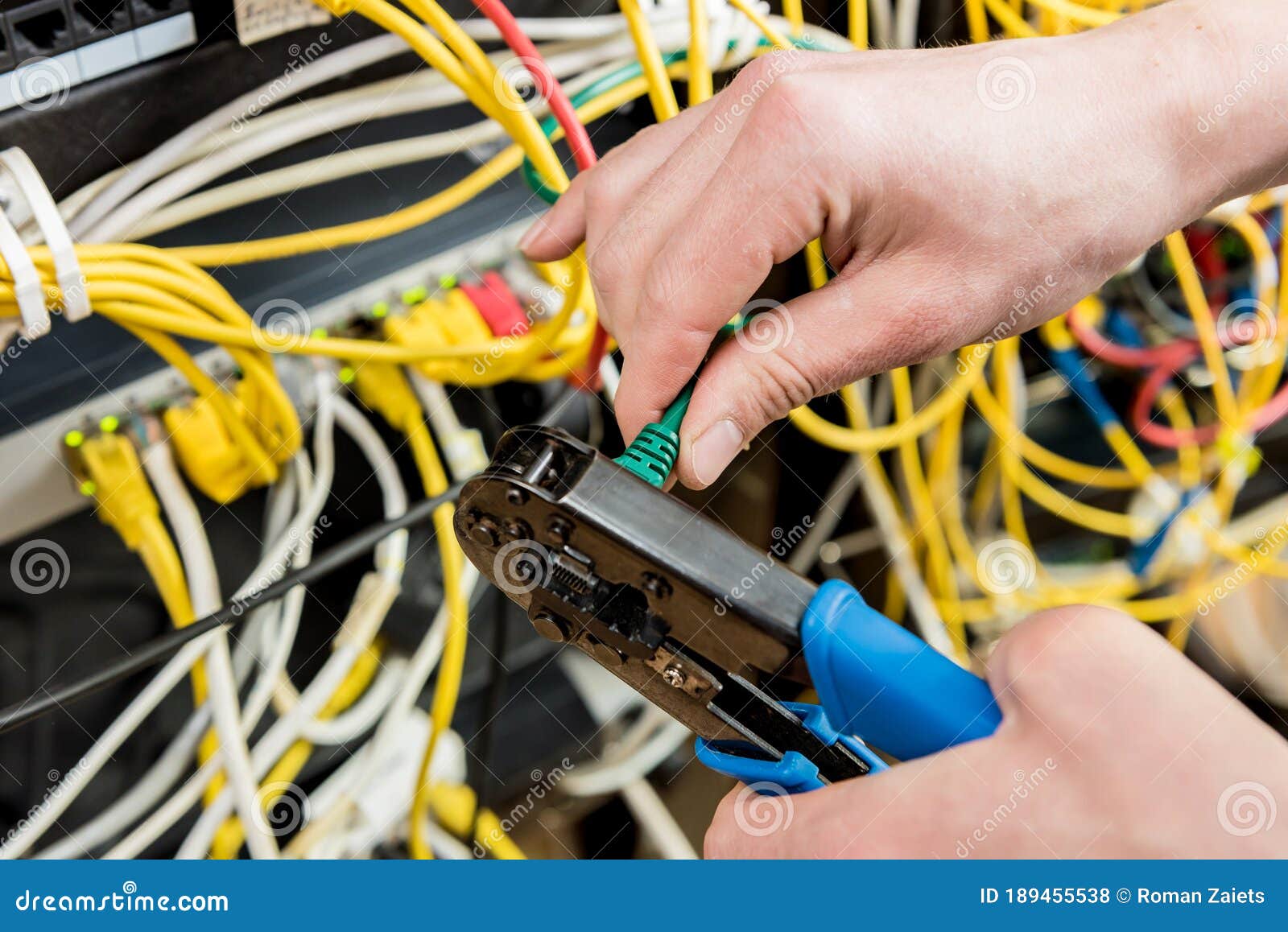 Network Engineer Working in Server Room. Connecting Network Cables To ...