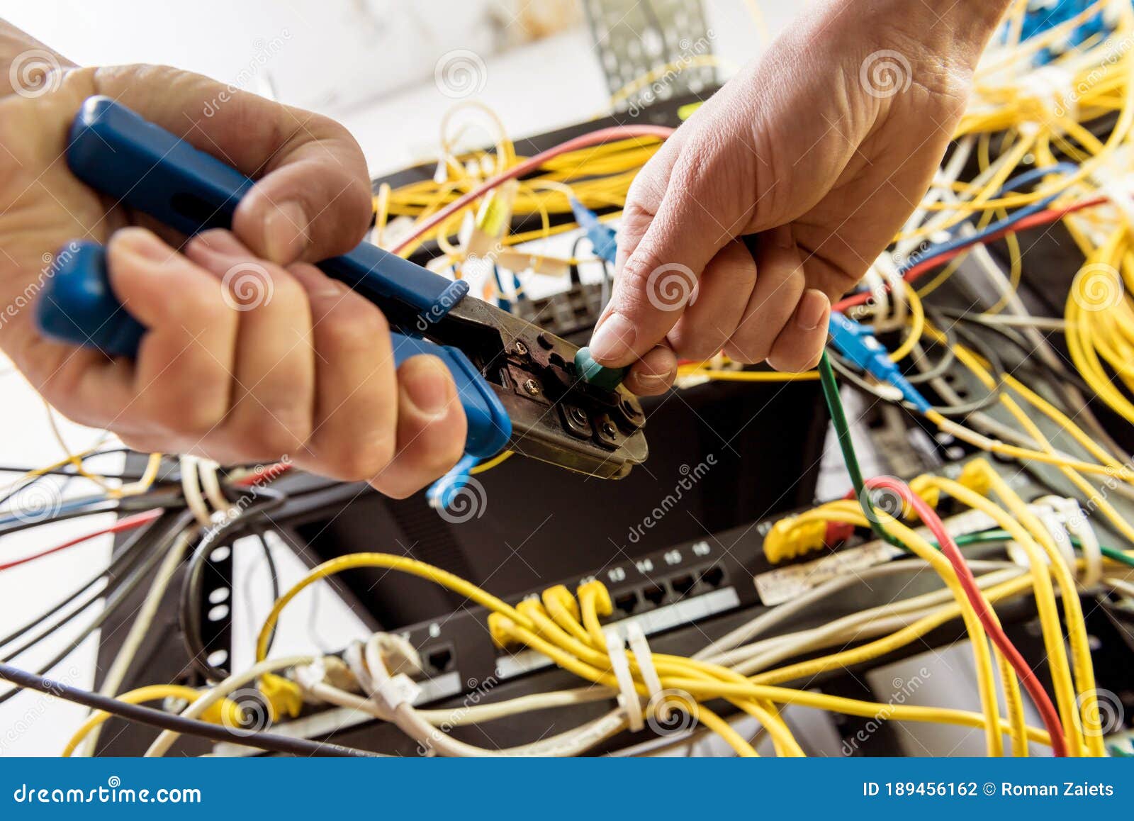 Network Engineer Working in Server Room. Connecting Network Cables To ...