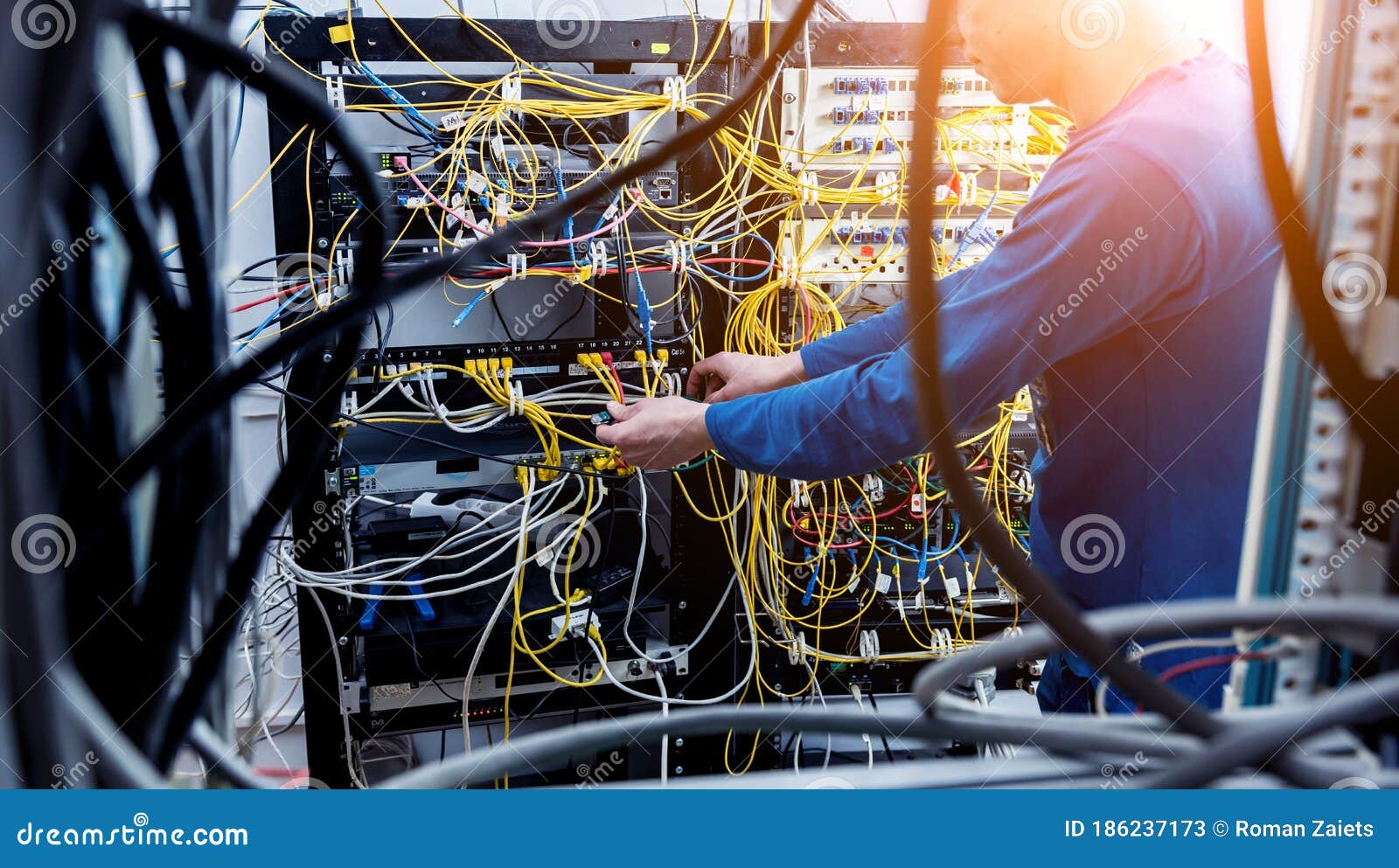 Network Engineer Working in Server Room. Connecting Network Cables To ...