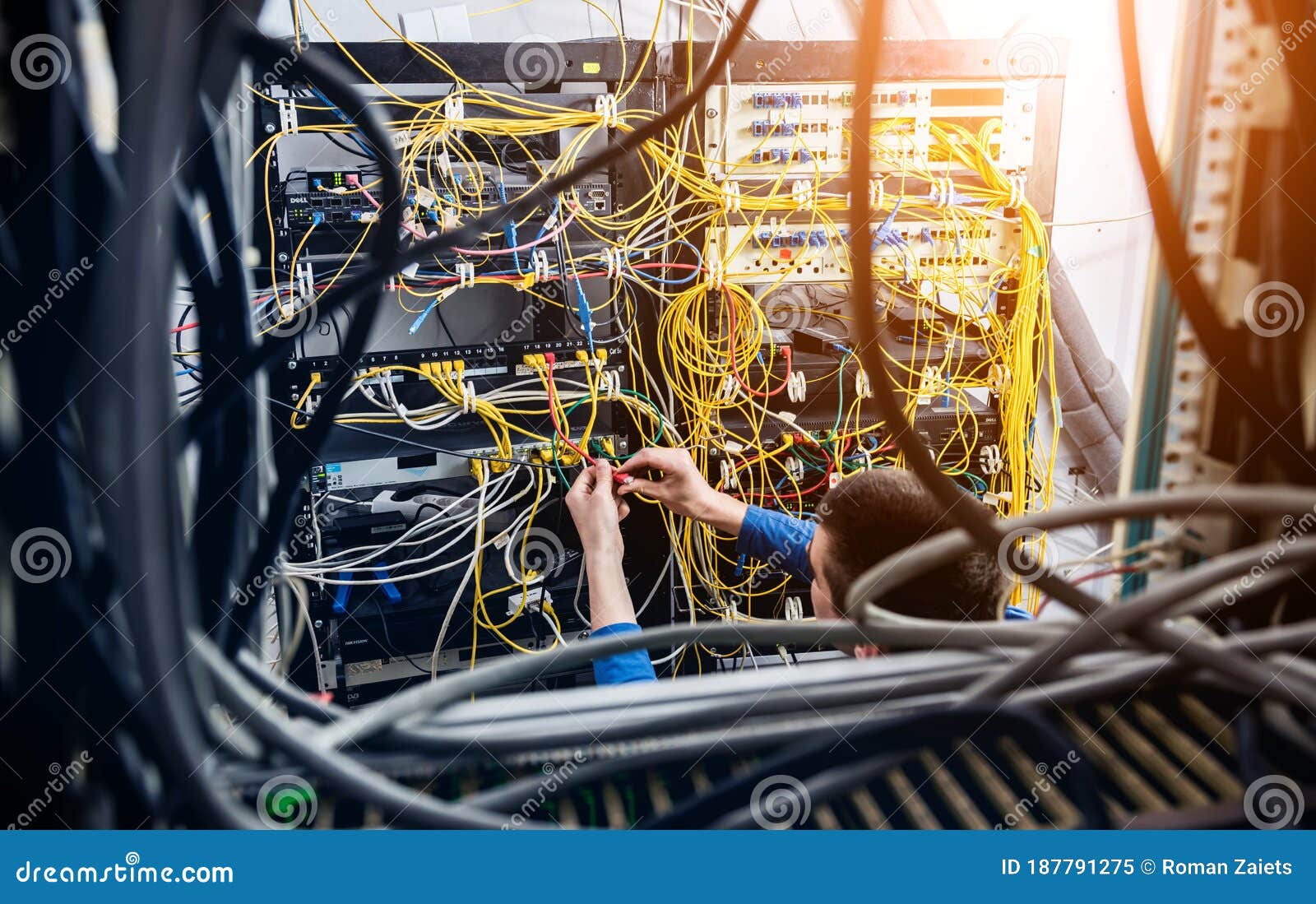 Network Engineer Working in Server Room. Connecting Network Cables To ...