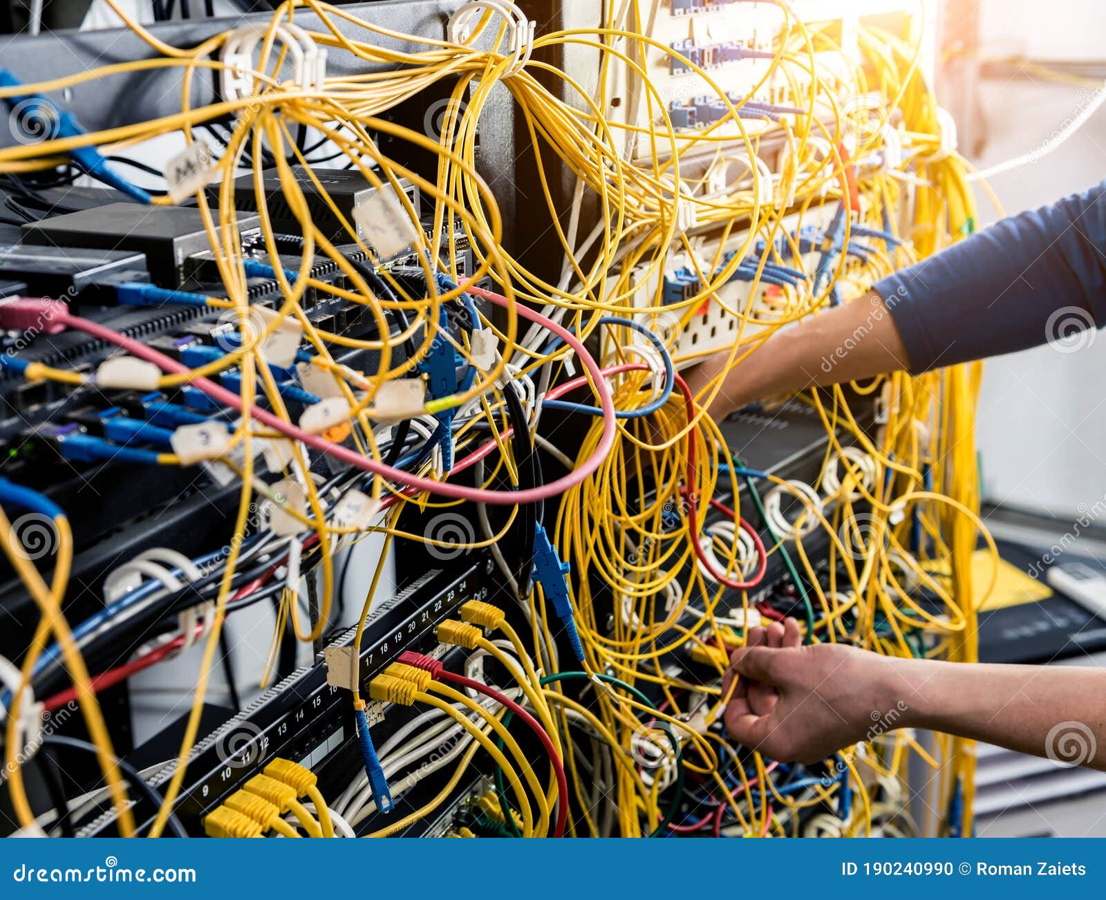 Network Engineer Working in Server Room. Connecting Network Cables To ...