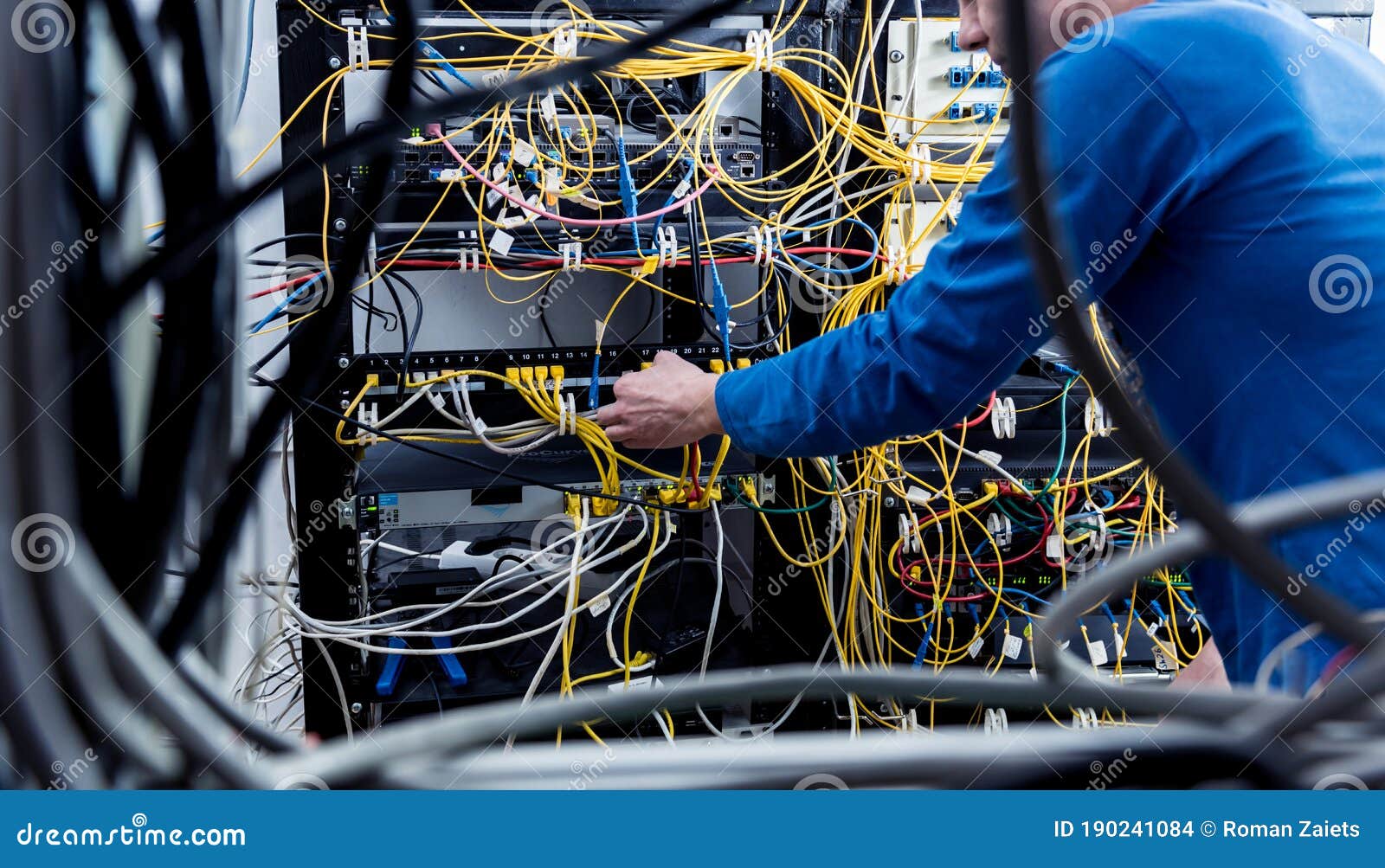 Network Engineer Working in Server Room. Connecting Network Cables To ... Network Engineer Working in Server Room. Connecting Network Cables To ...