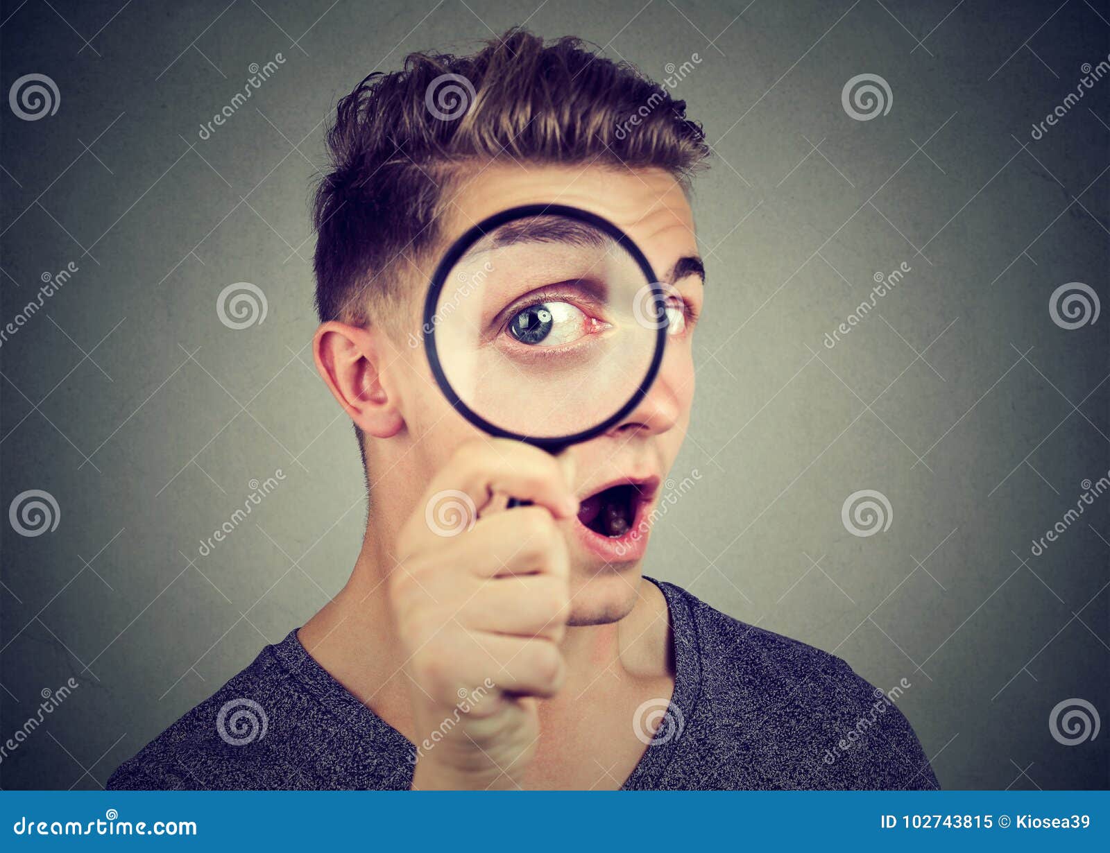 Neugieriger Junger Mann, Der Durch Eine Lupe Schaut Stockbild - Bild ...