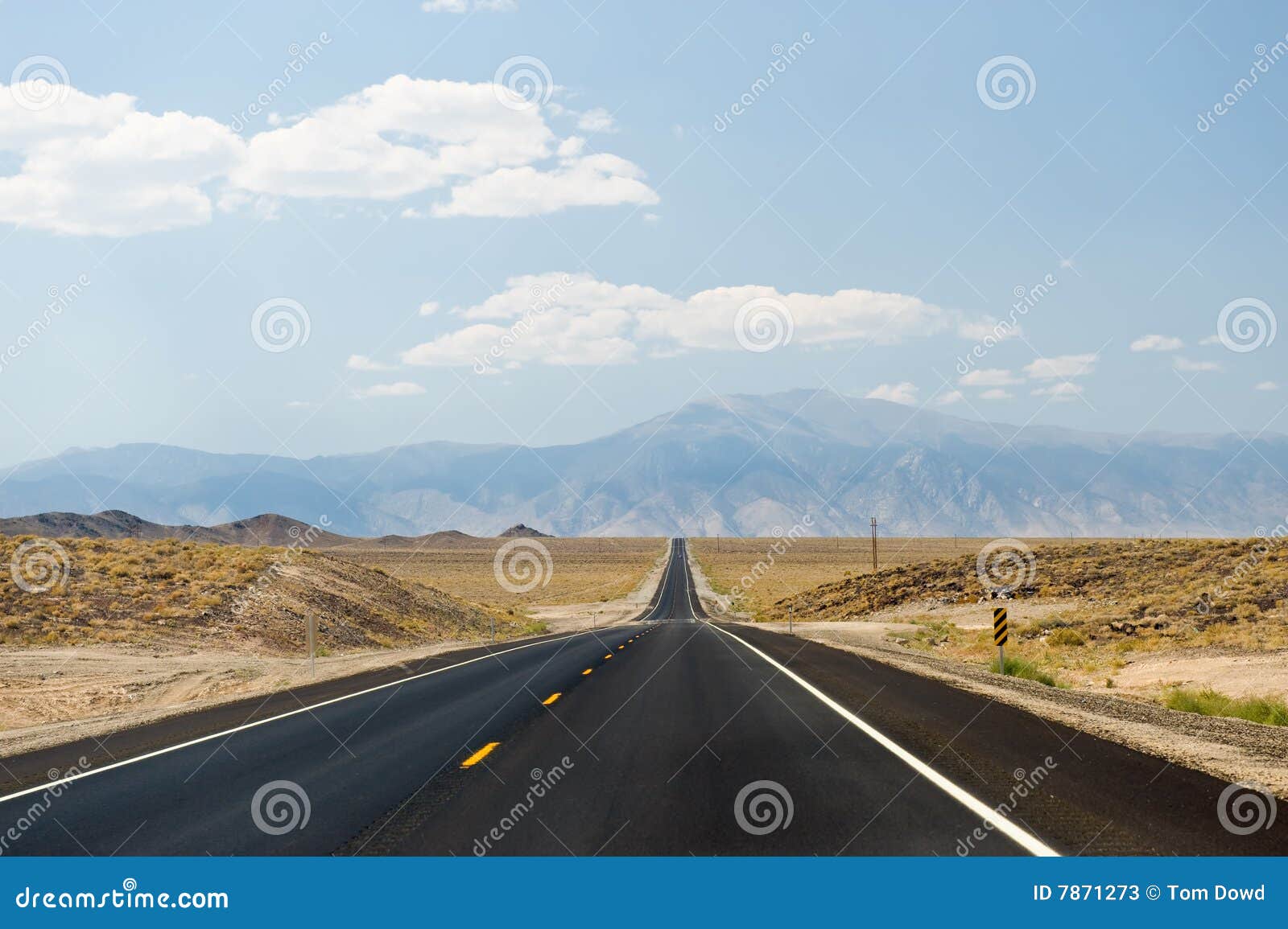 A Highway Receding To Perspective Toward A Mountain Range In A Desert ...